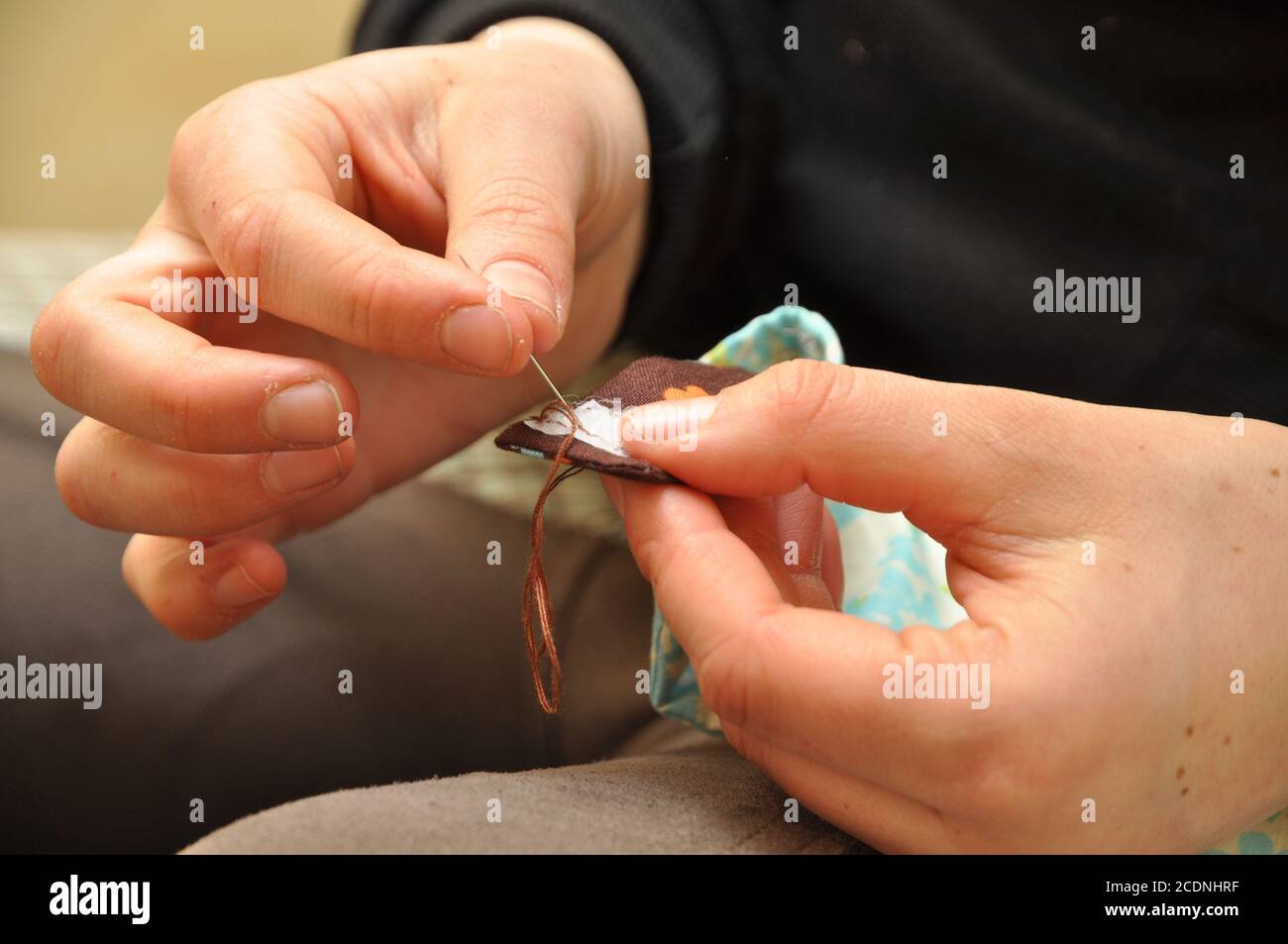 Hands with sewing needle Stock Photo - Alamy