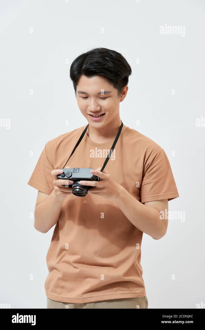 Attractive handsome young Asian man using camera over white background ...