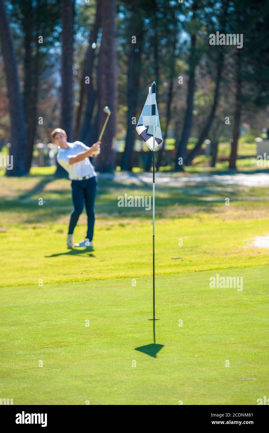 image of a golfer playing a chip shot onto the green on a golf course ...