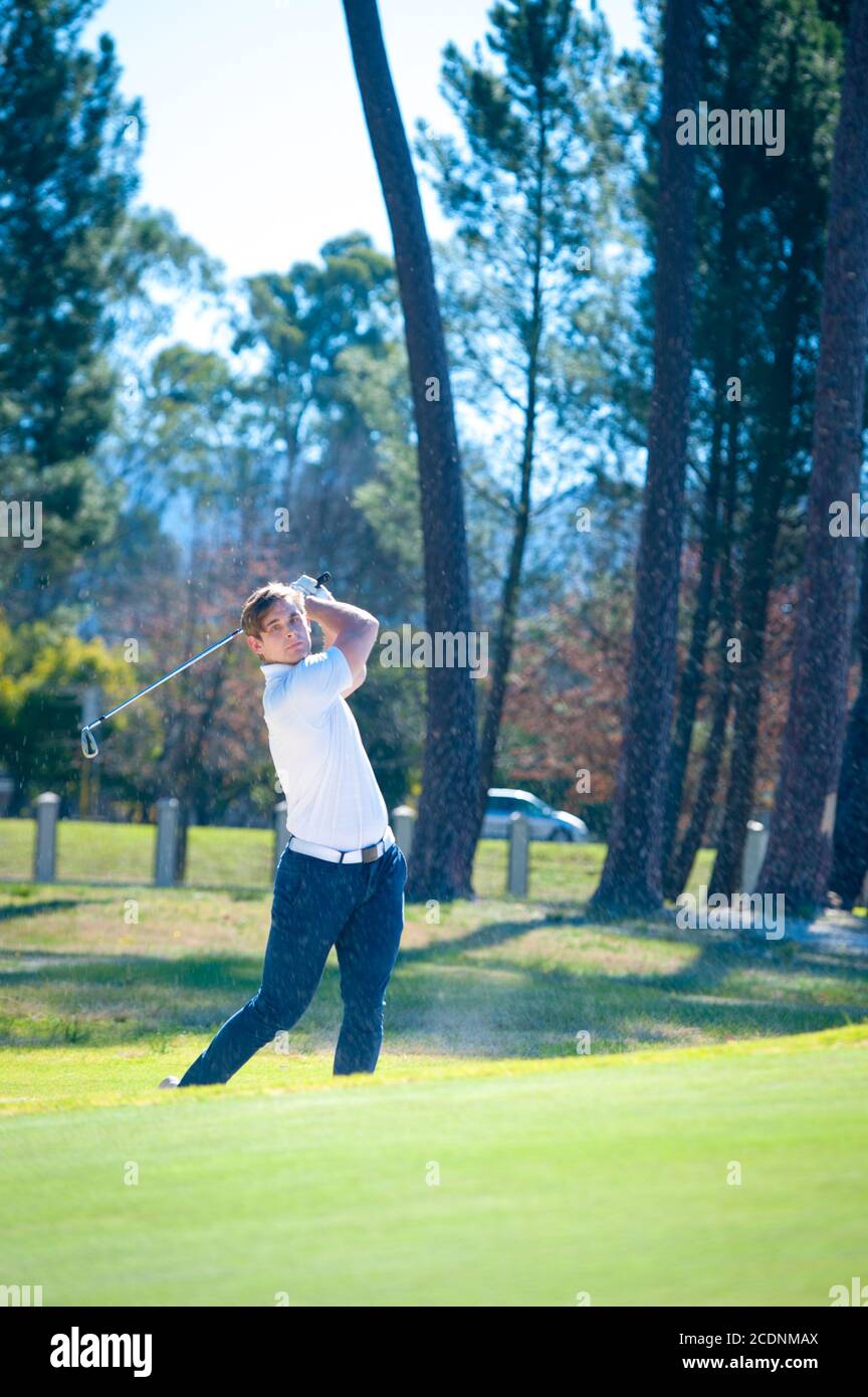 image of a golfer playing a chip shot onto the green on a golf course ...