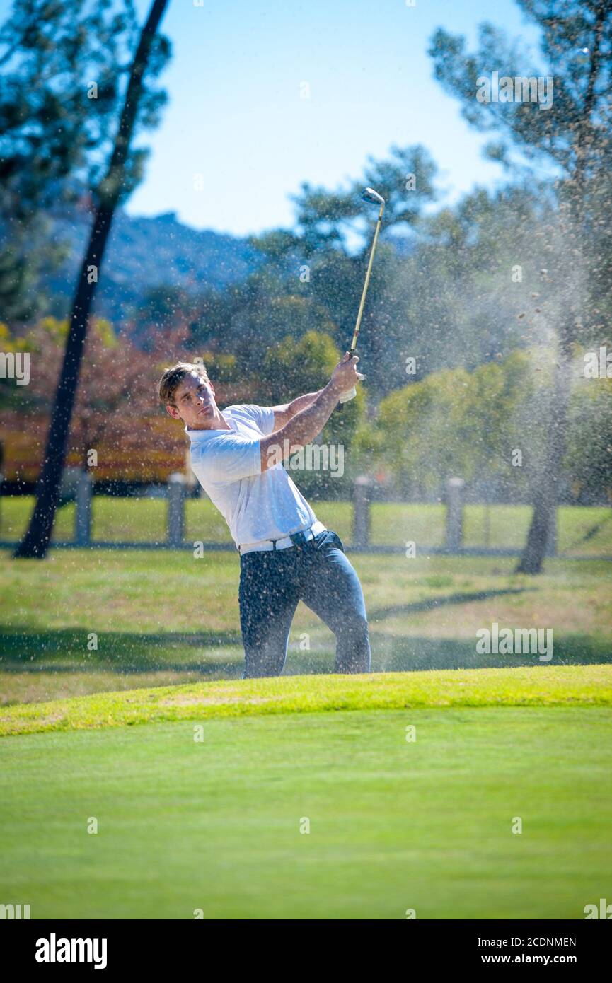 image of a golfer playing a chip shot onto the green on a golf course ...