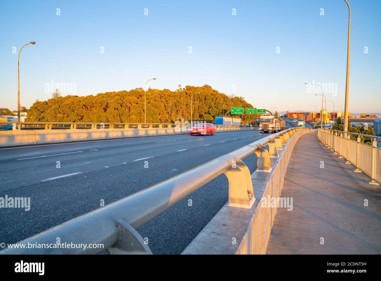 Early sun casts golden glow over Tauranga Harbour Bridge as business ...