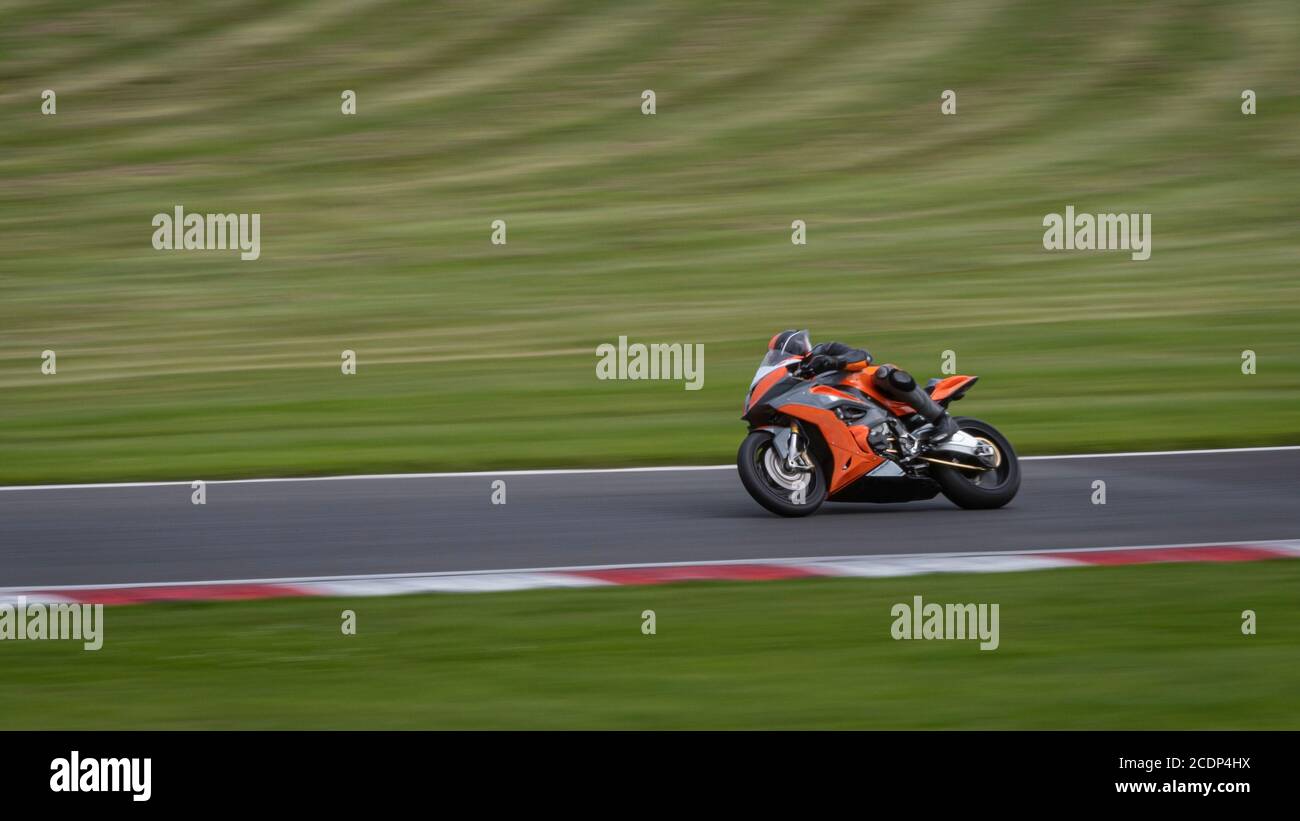 A panning shot of a racing bike cornering as it circuits a track Stock ...