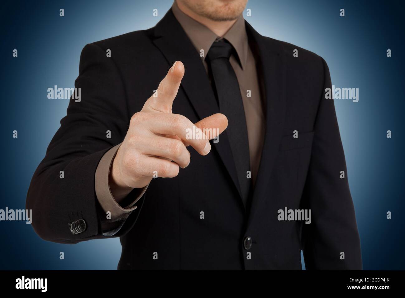Portrait of businessman pointing finger at viewer / blue background ...