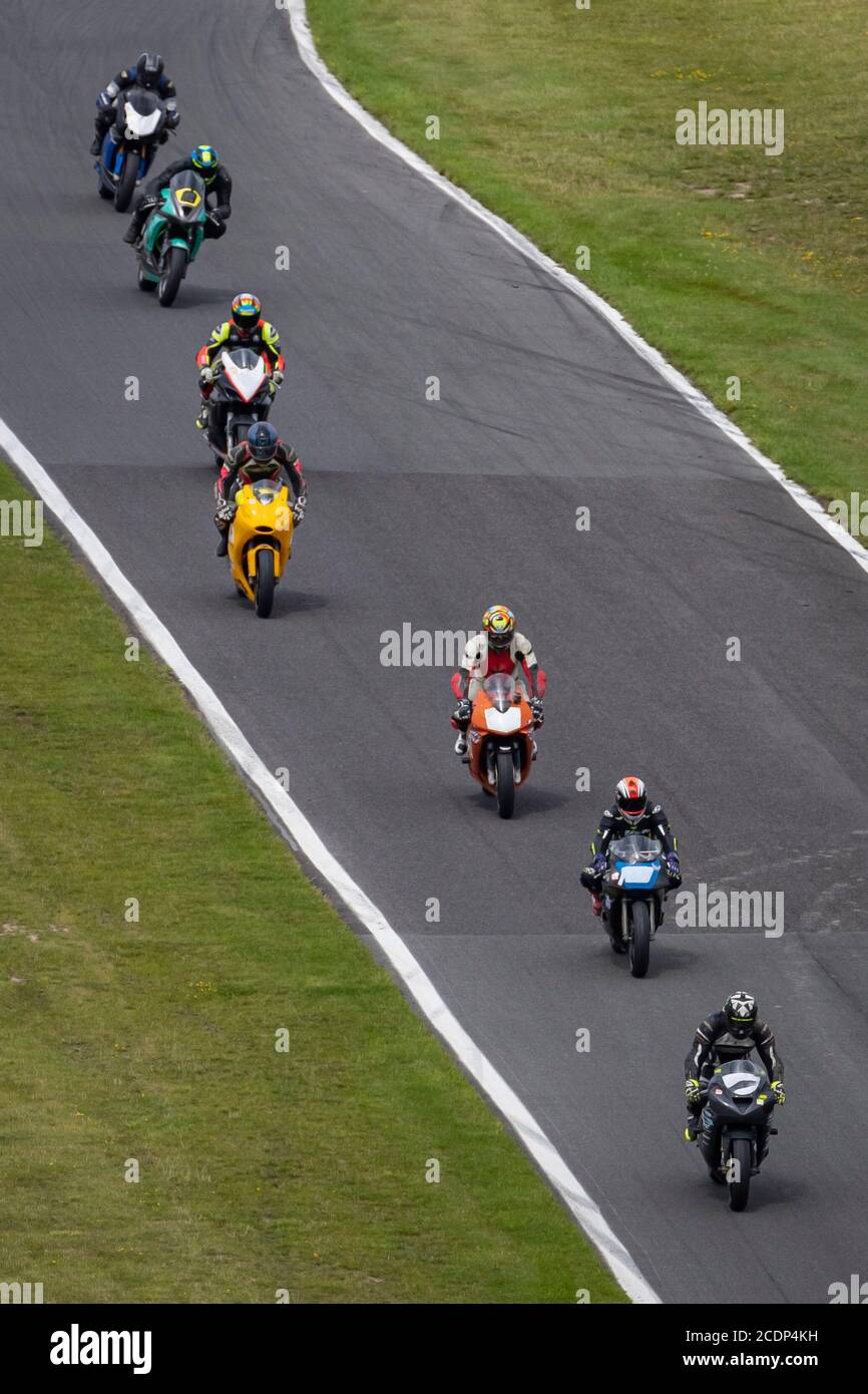 A shot of several racing bikes cornering as they circuit a track Stock ...