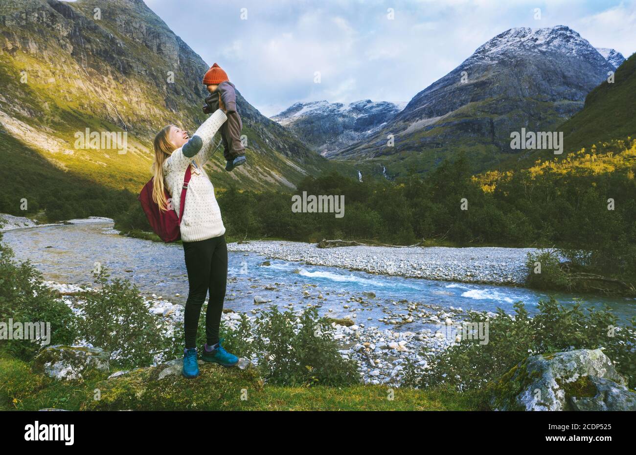 Family vacation mother holding up infant baby travel hiking in ...