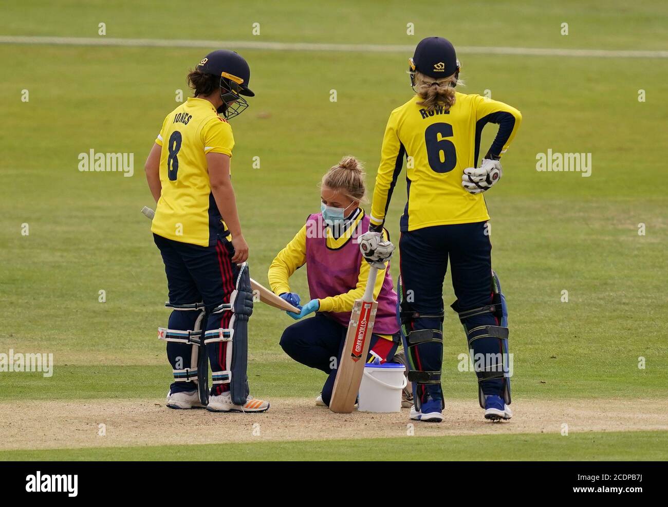 South East Star's Hannah Jones (left) has her bat sanitised during the ...