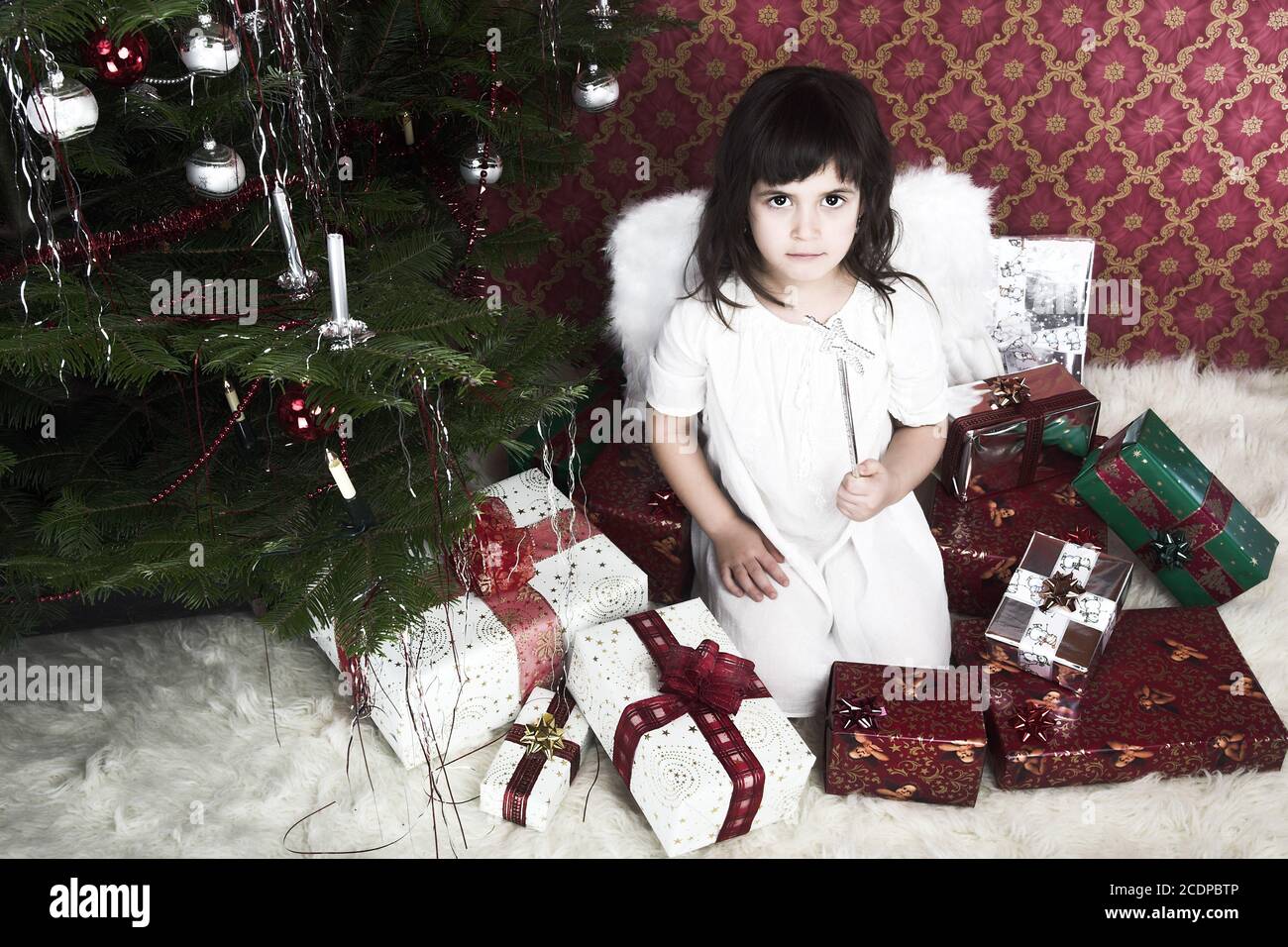 Young girl in christmas setting with angel wings and gift boxes Stock ...