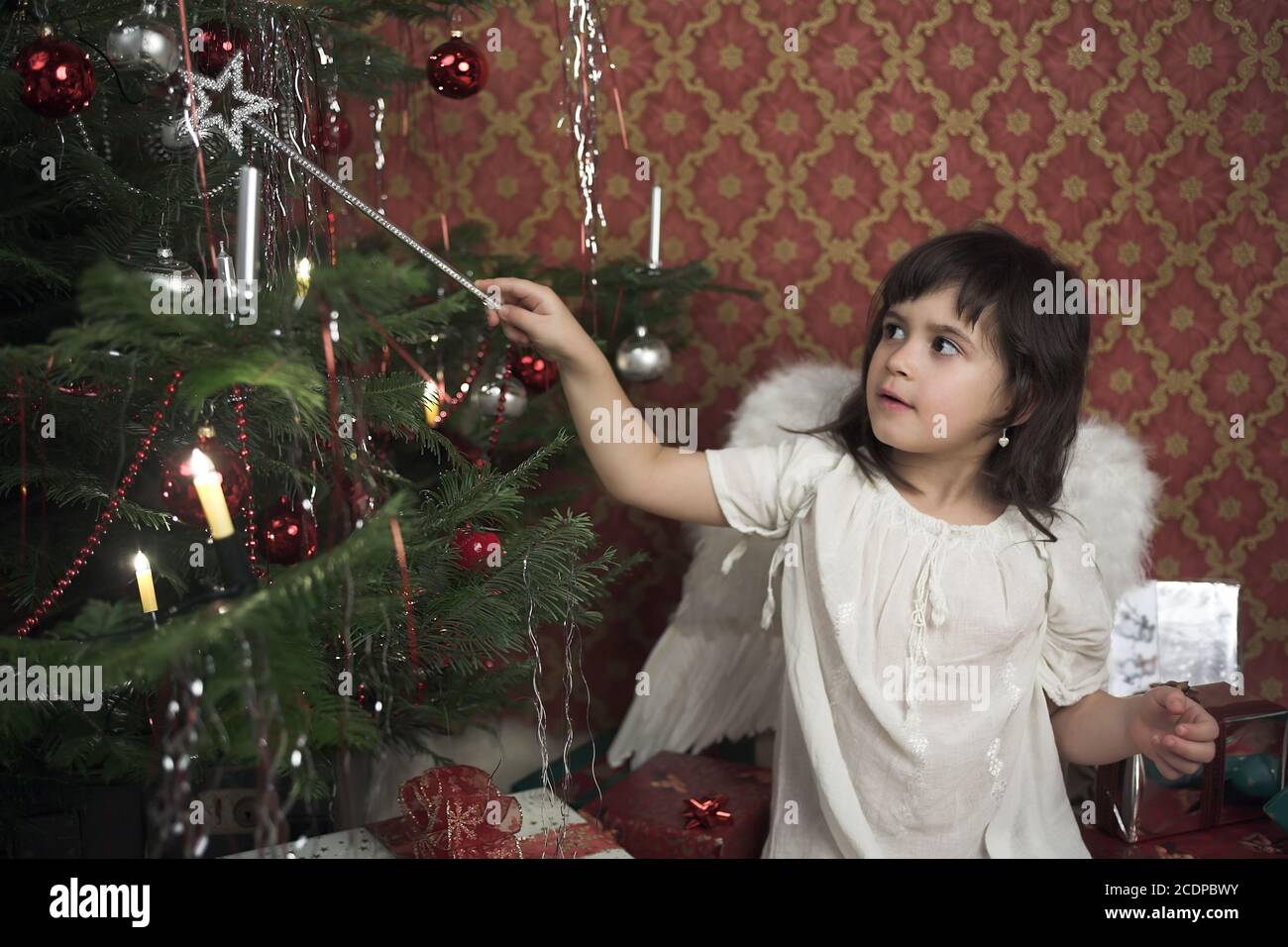 Young girl in christmas setting with angel wings and gift boxes Stock ...