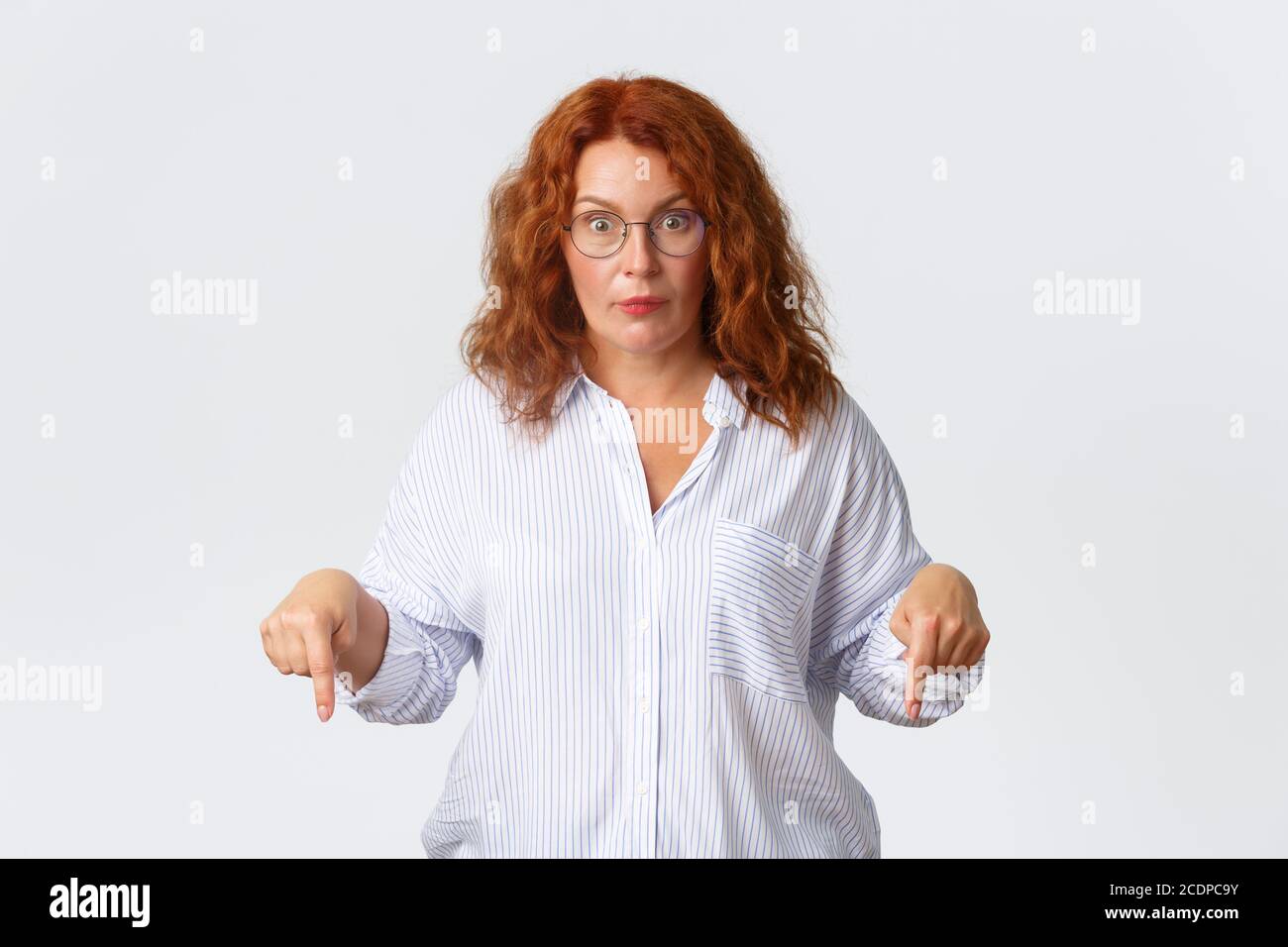 Shocked and speechless middle-aged redhead woman in glasses stare at ...