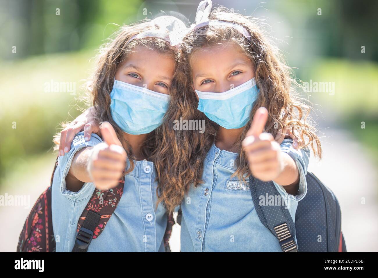 Twin sisters with face masks go back to school during the Covid-19 ...