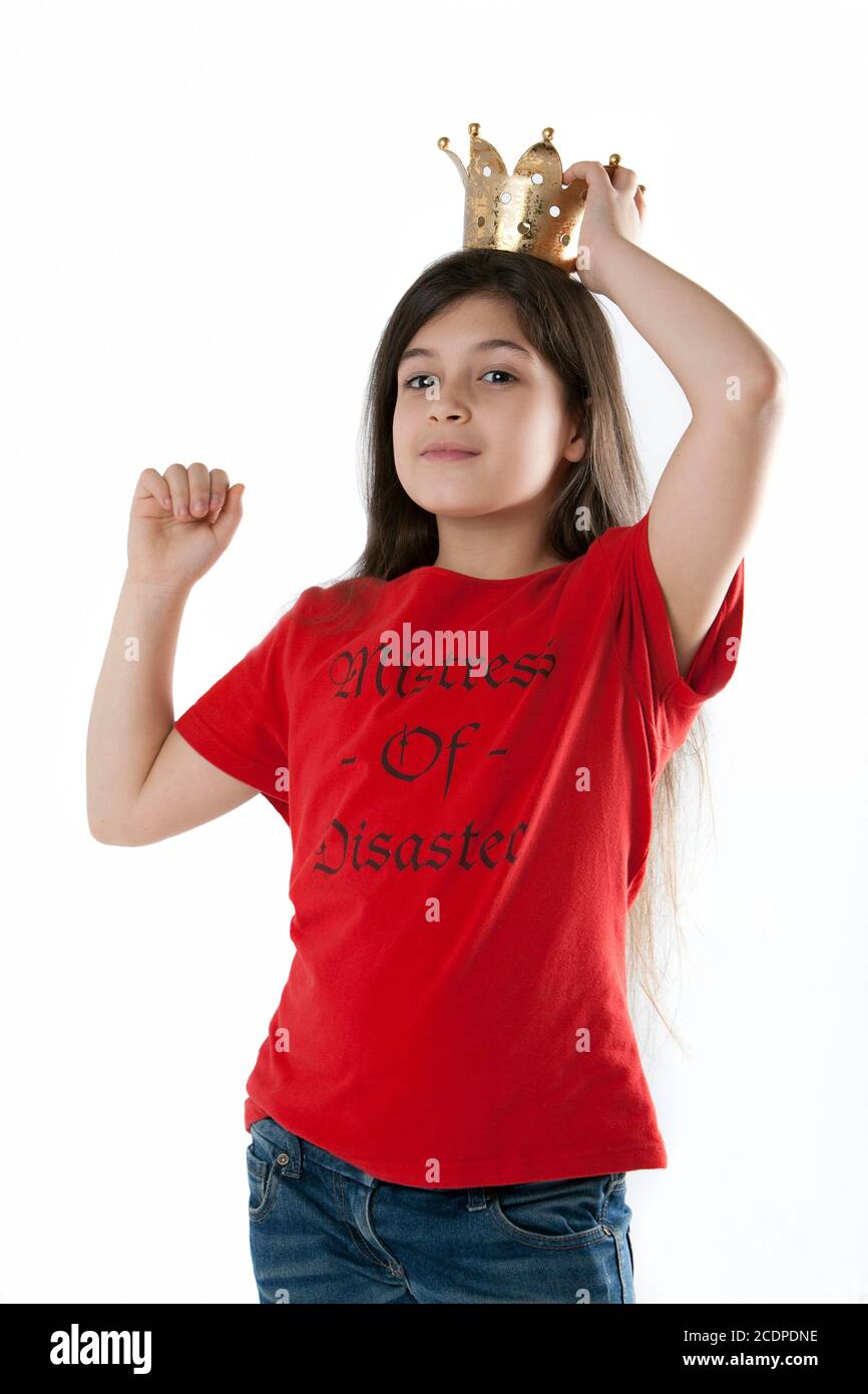 Cheeky looking young girl in a red T-shirt with cheeky slogan and ...