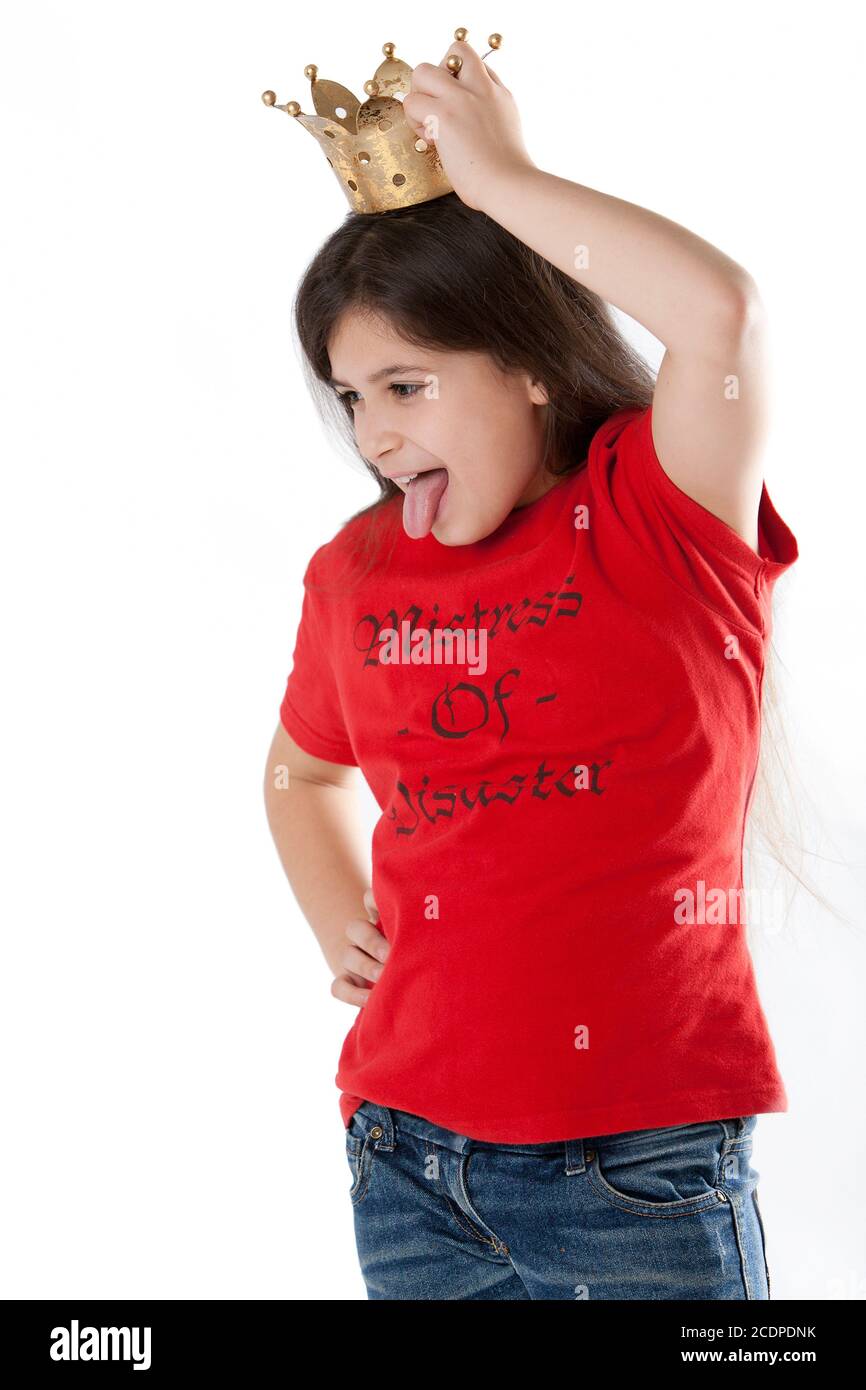 Cheeky looking young girl in a red T-shirt with cheeky slogan and ...