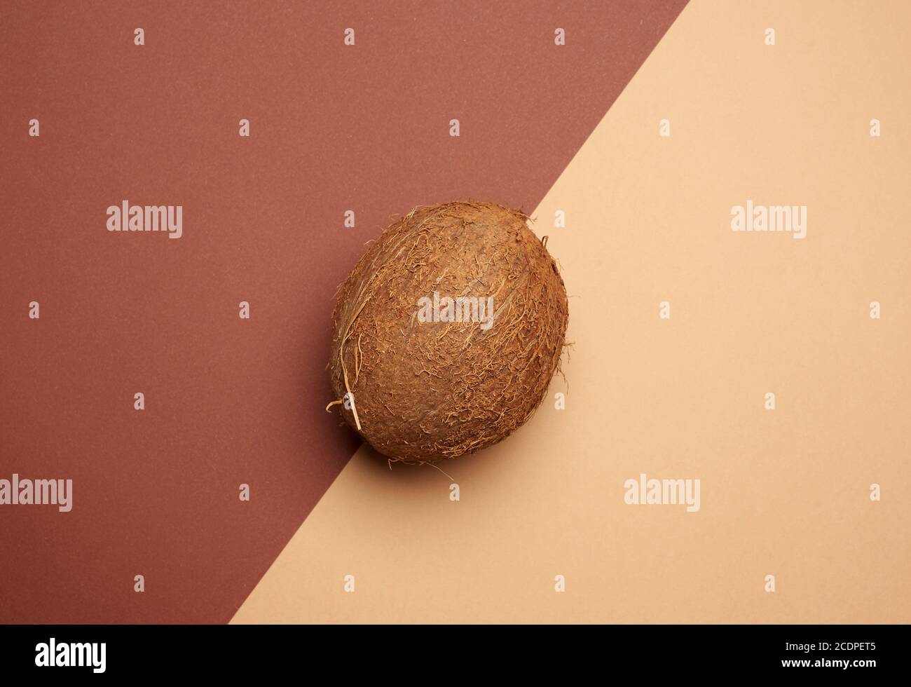 ripe whole round coconut on a brown background, top view Stock Photo ...