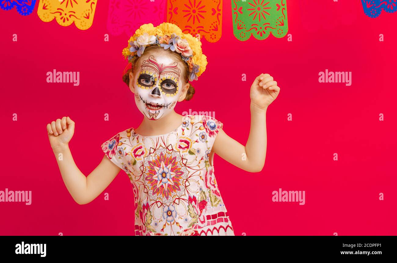 Adorable zombie in flower wreath posing on red background. Happy child ...