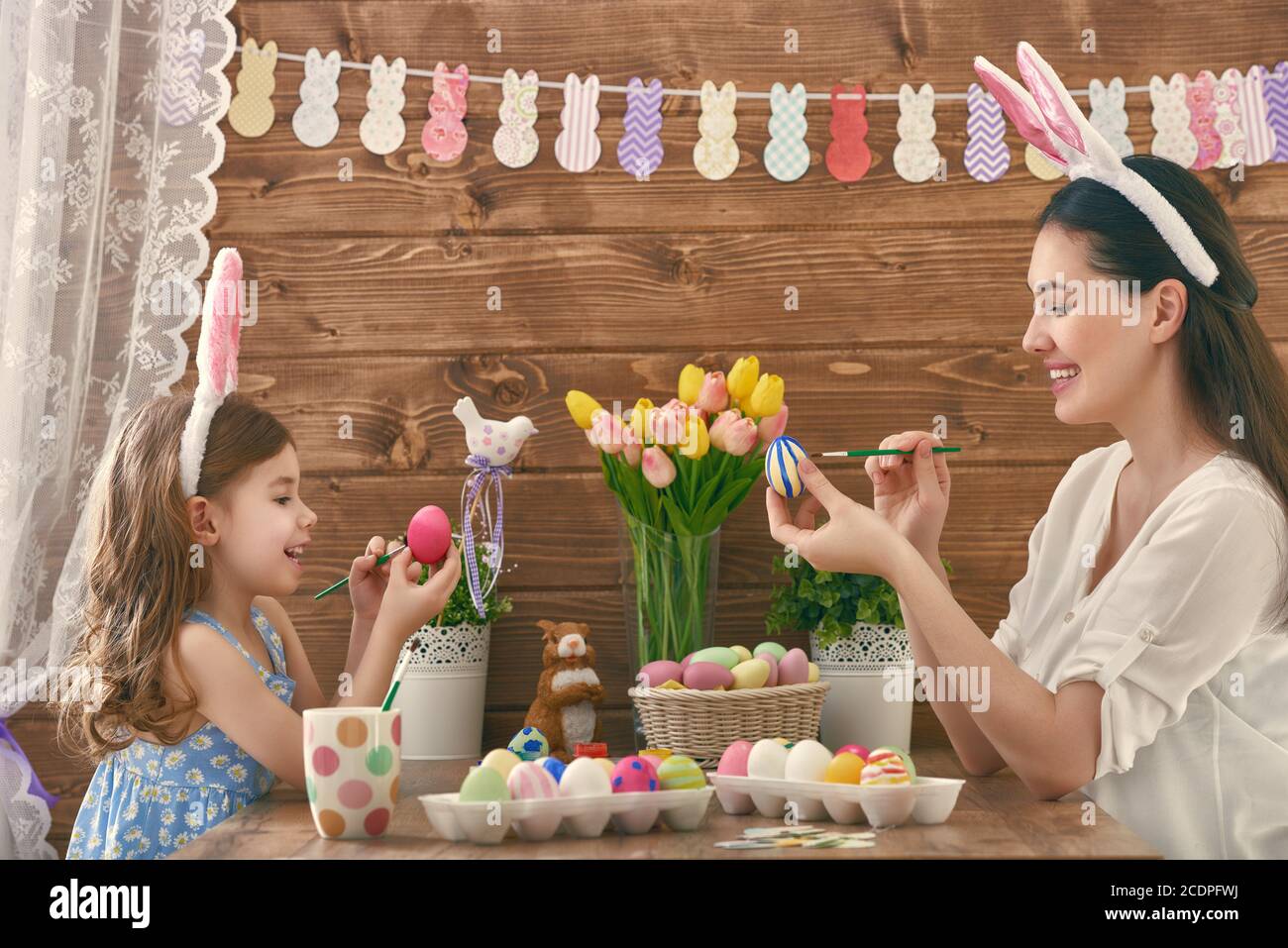 Happy easter! A mother and her daughter painting Easter eggs. Happy ...