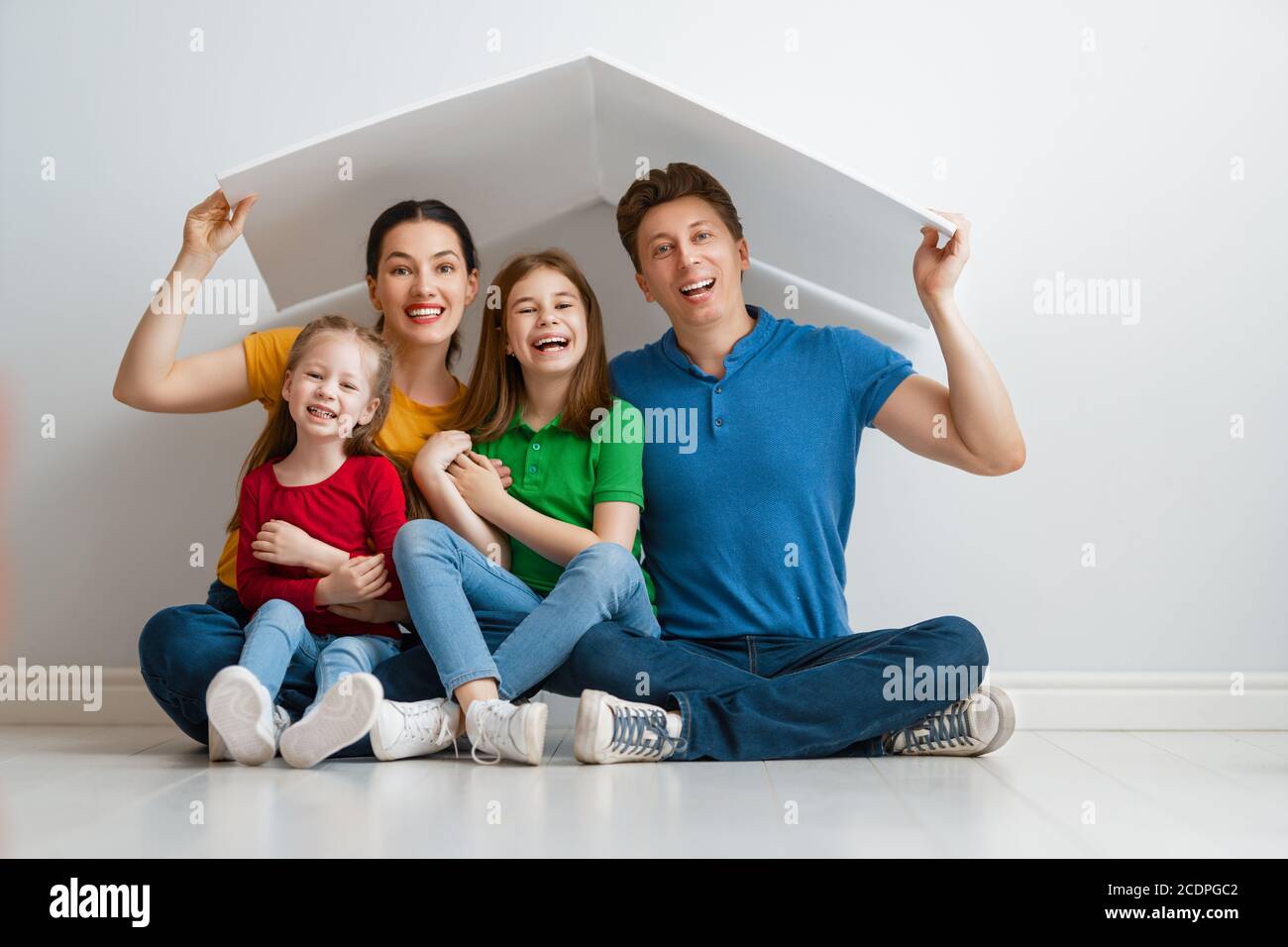 Mother, father and children girls in the house with a symbol of roof ...