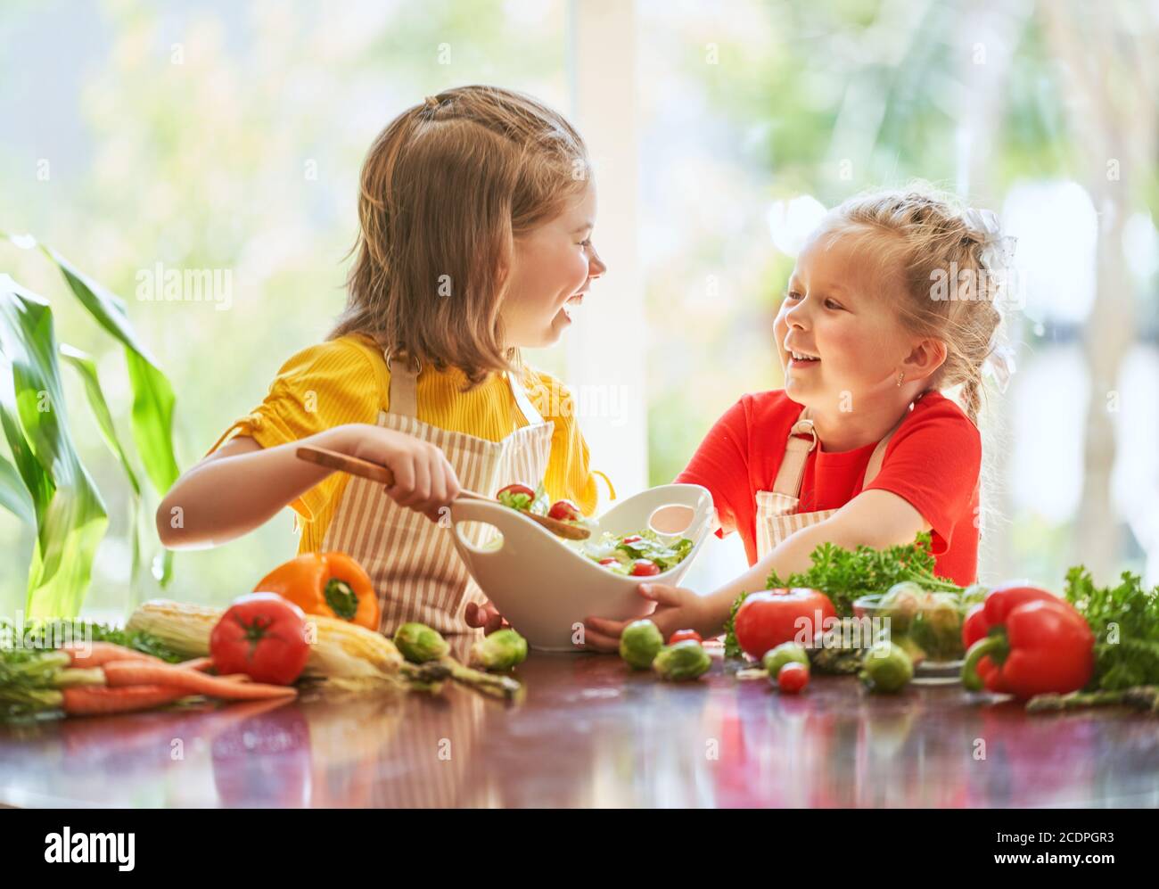 Healthy food at home. Happy family in the kitchen. Two cute funny ...