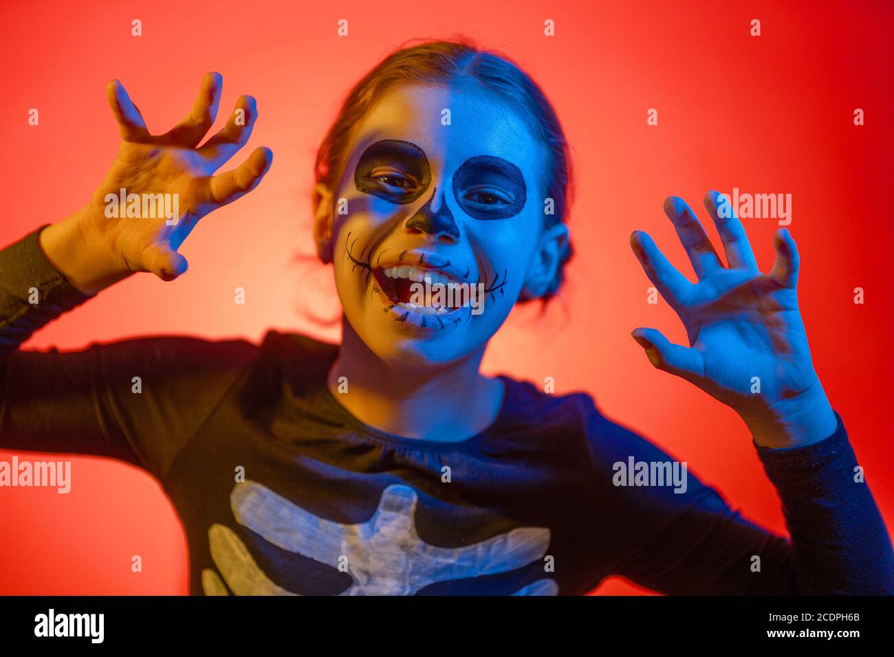 Happy Halloween! Cute little skeleton at party in colorful lighting ...