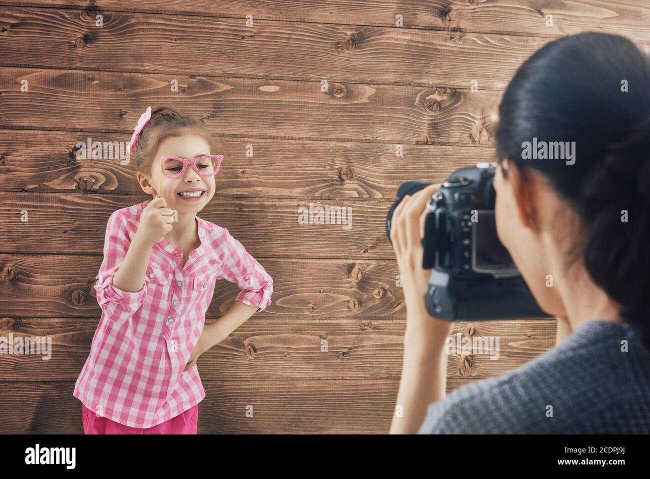 Photographer in motion. Young woman photographer and child girl having ...