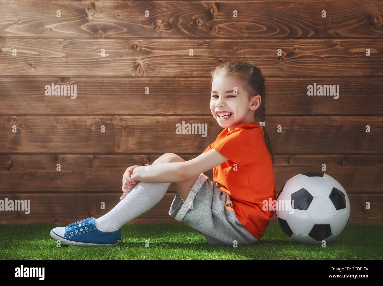 Cute little child dreams of becoming a soccer player. Girl plays ...