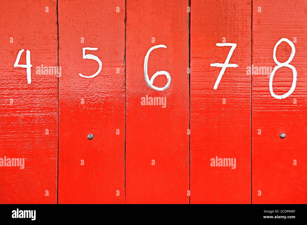 The entrance of a shop is closed with red painted wooden panels, which ...