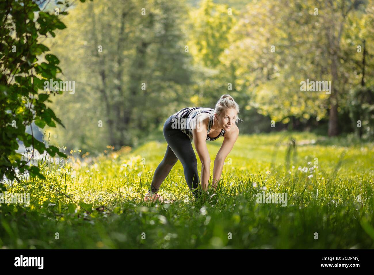 Blonde girl doing pyramid pose in the nature. Parsvottonasana. Yoga ...