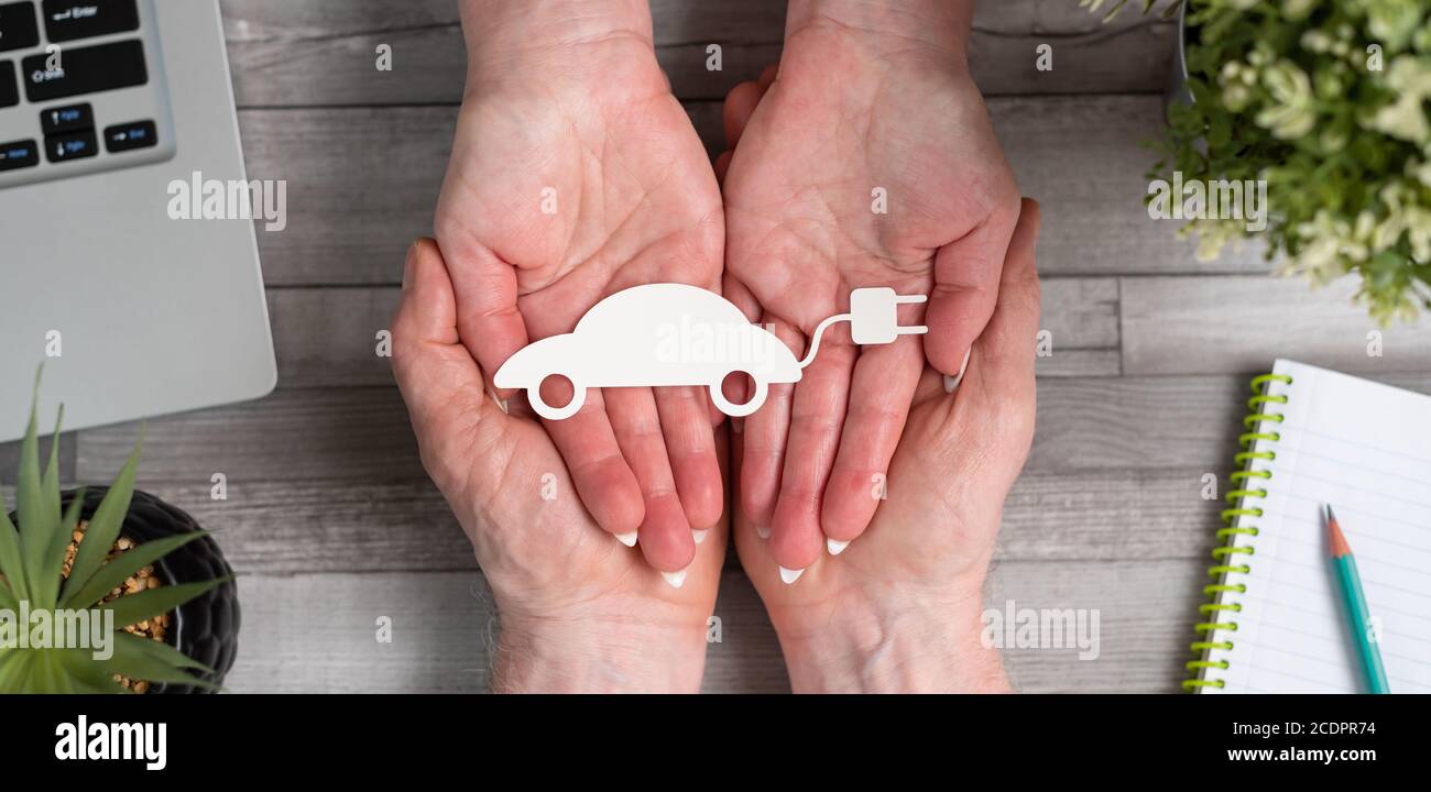 Hands holding a paper electric car; Concept of eco friendly car Stock ...