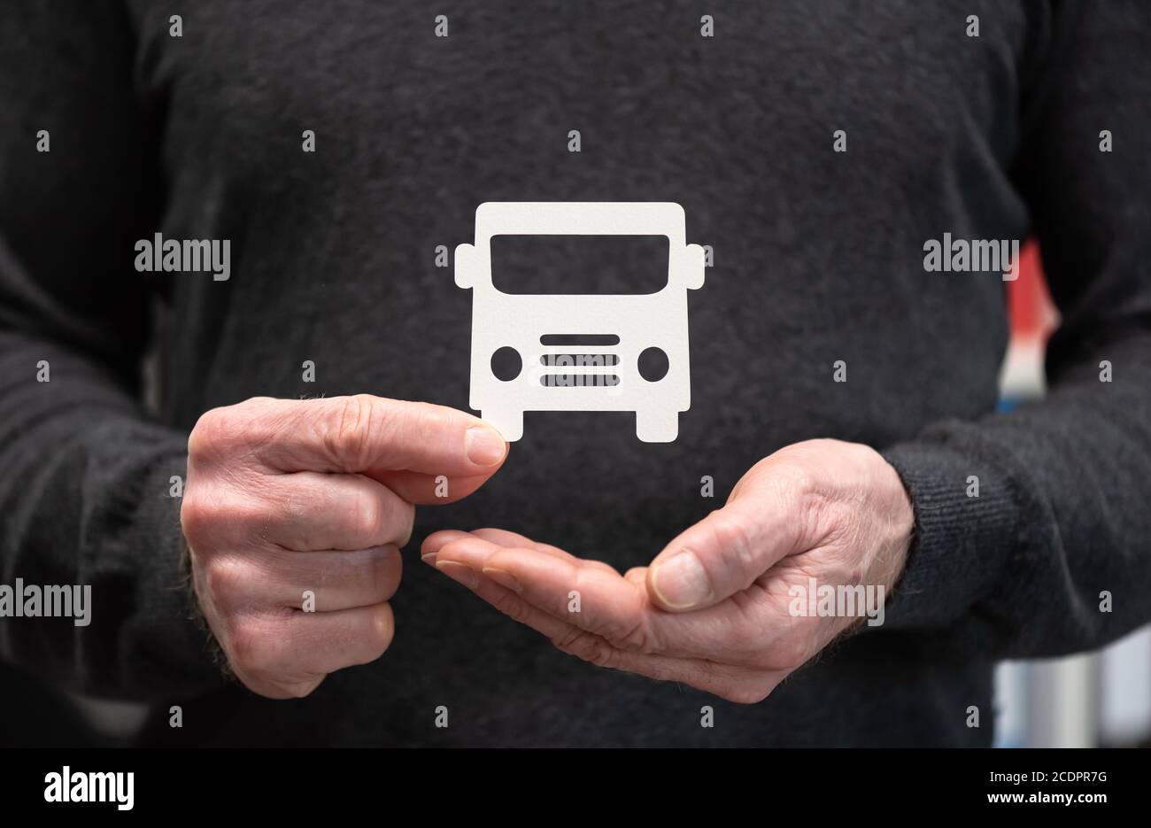 Man holding a paper bus; Concept of bus insurance Stock Photo - Alamy