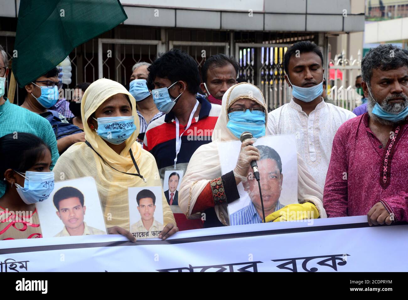 Relatives hold portraits of their missing family members as they form ...