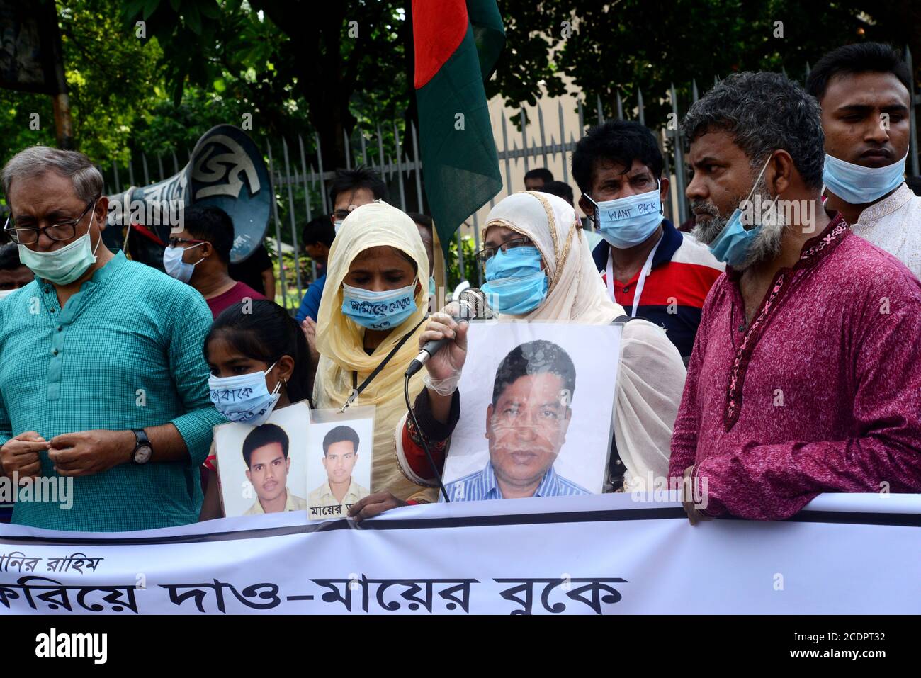 Relatives hold portraits of their missing family members as they form ...