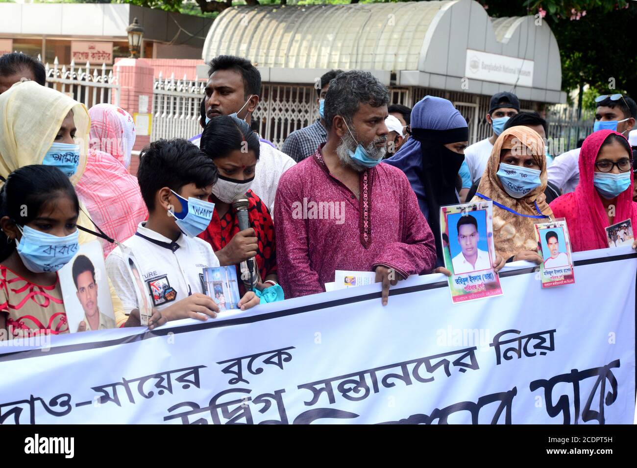 Relatives hold portraits of their missing family members as they form ...