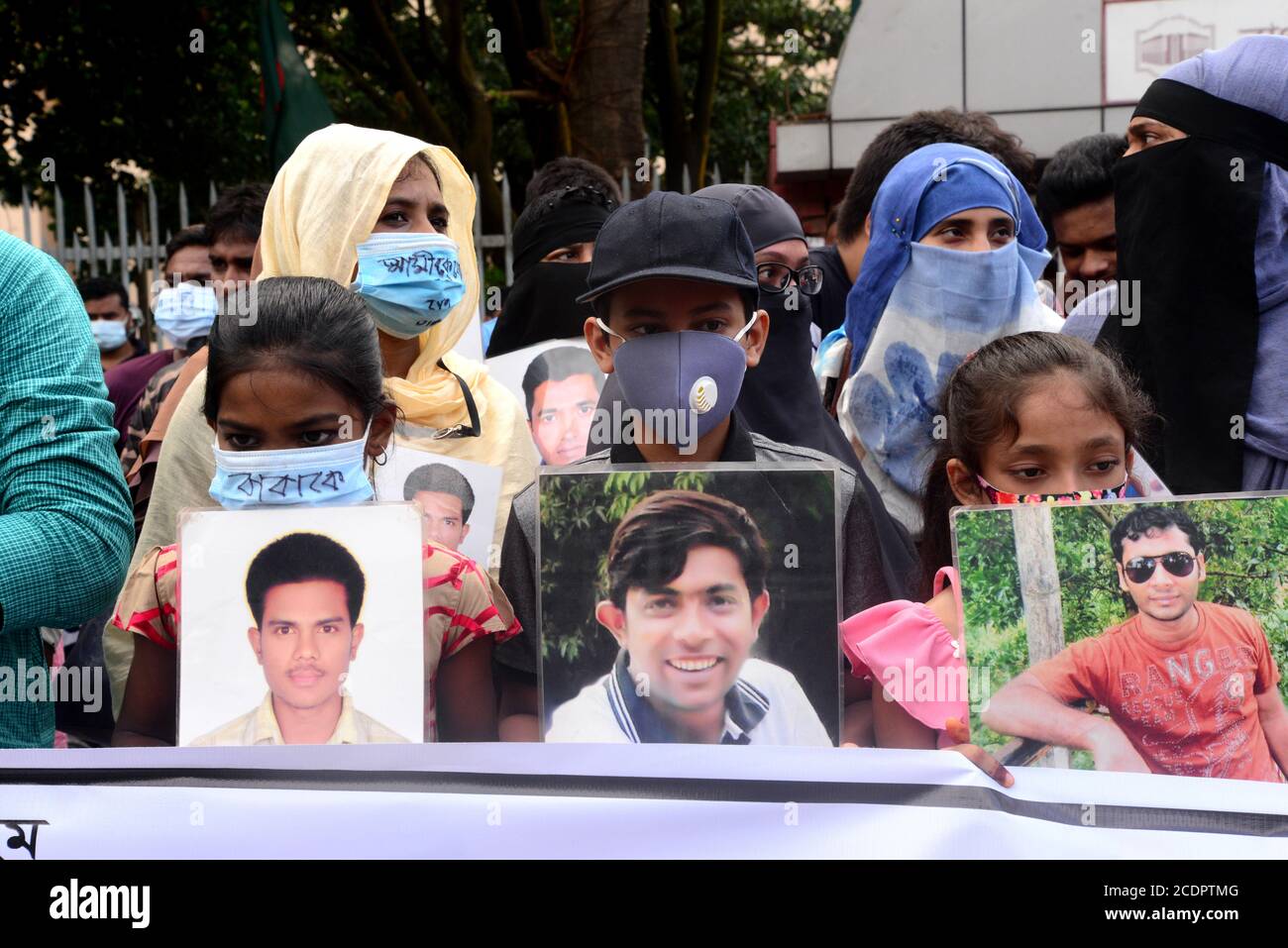 Relatives hold portraits of their missing family members as they form ...