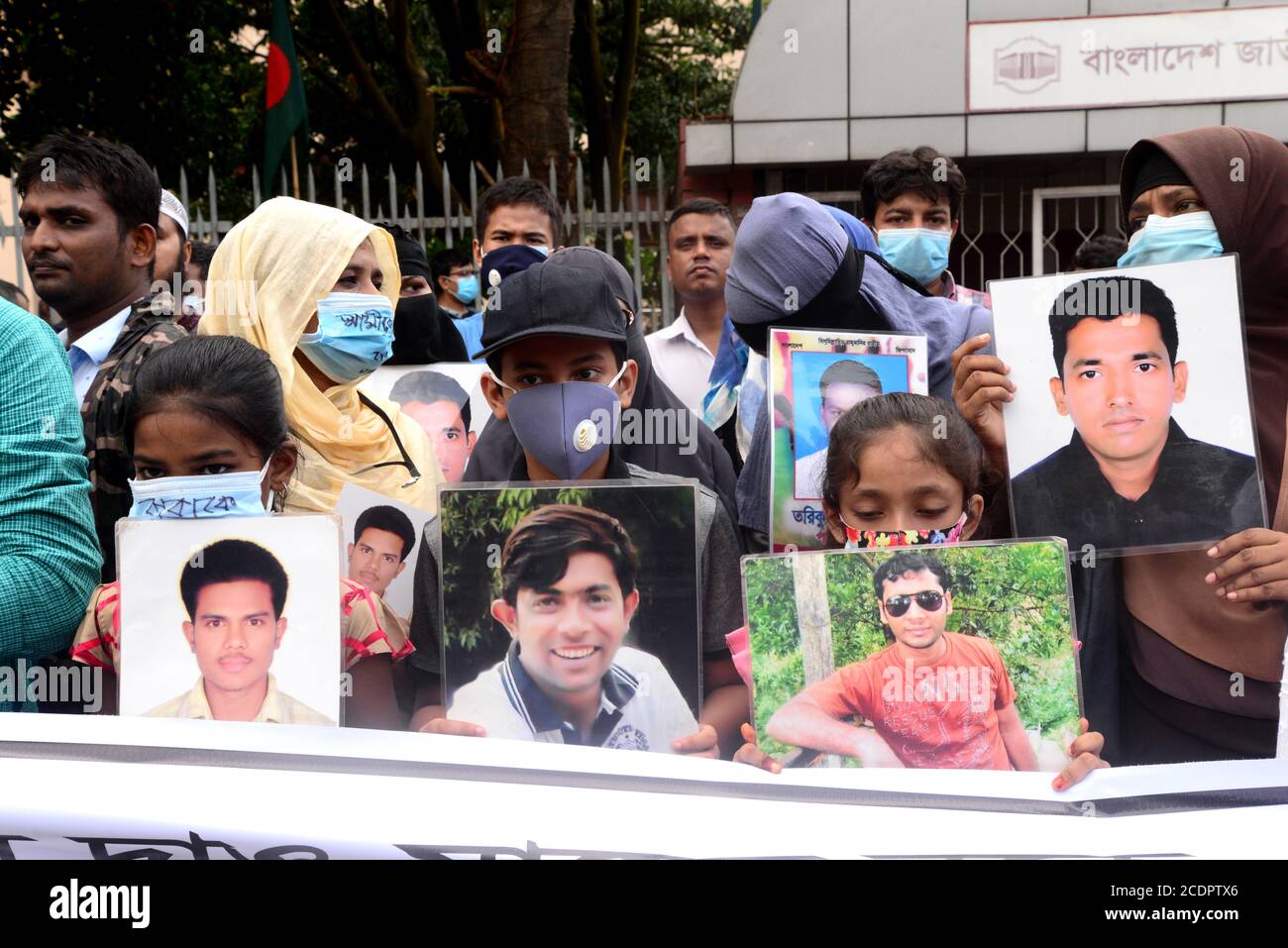 Relatives hold portraits of their missing family members as they form ...