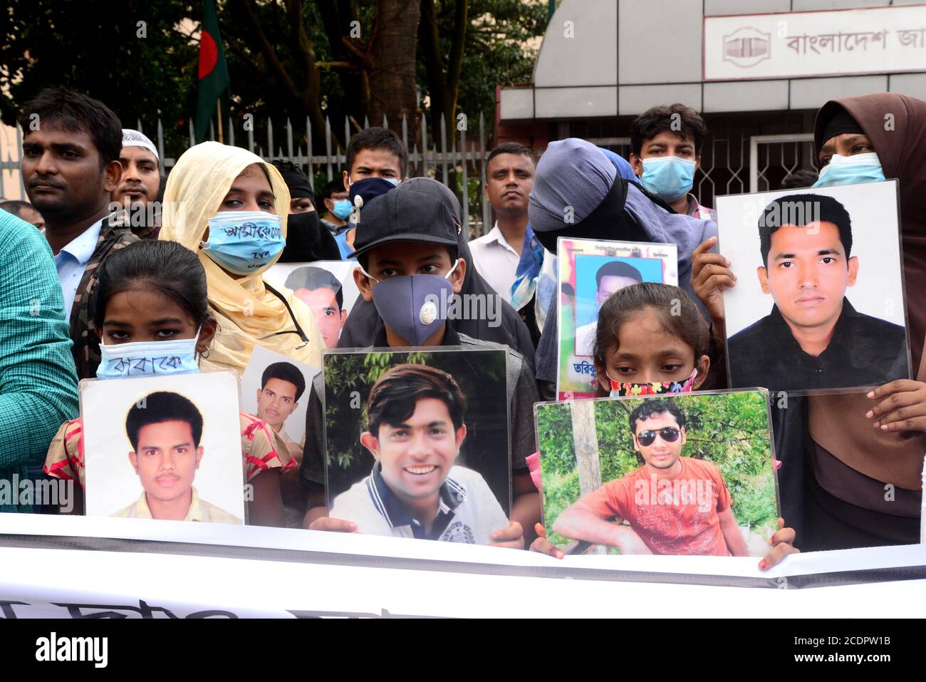 Relatives hold portraits of their missing family members as they form ...