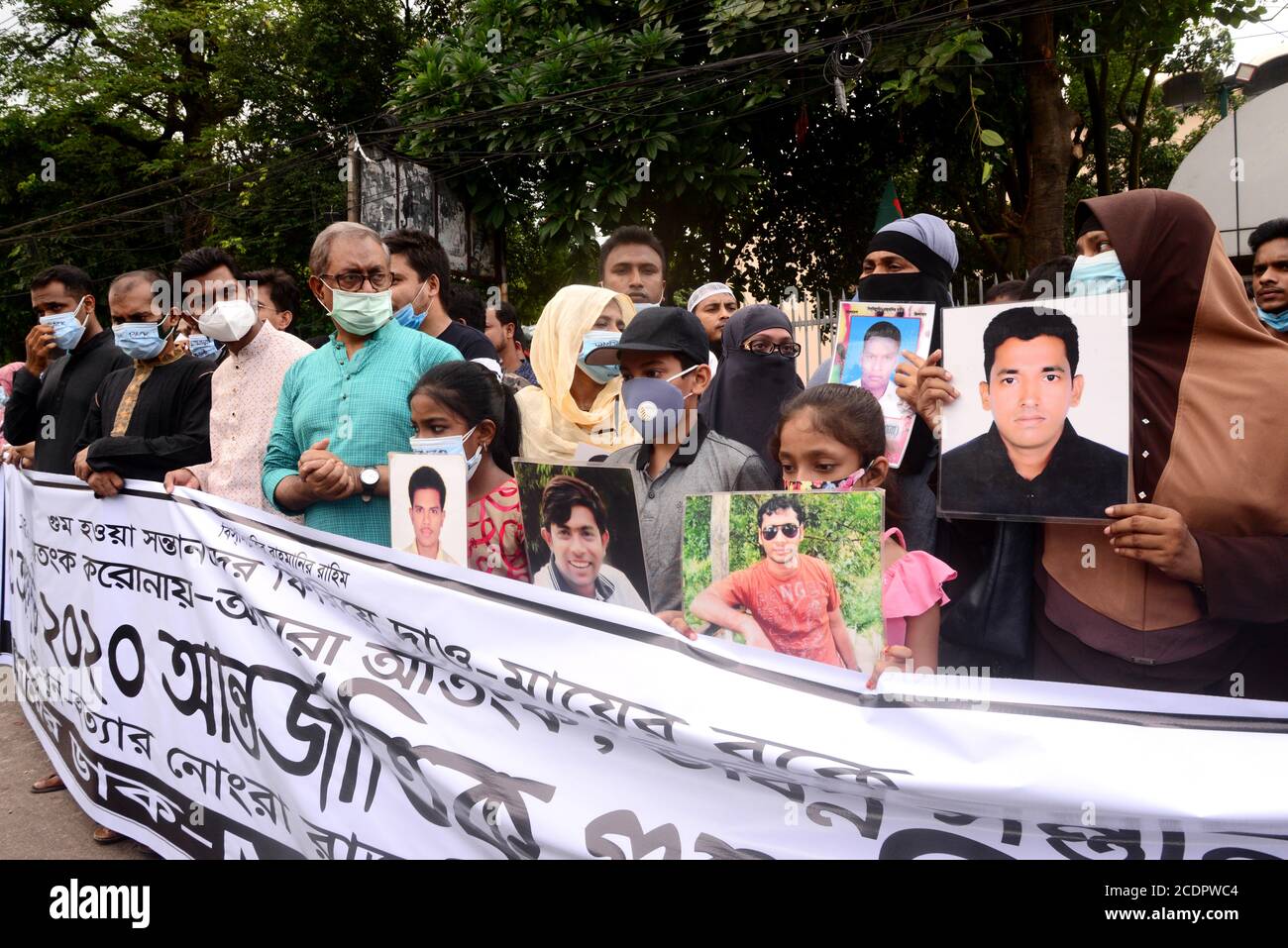 Relatives hold portraits of their missing family members as they form ...