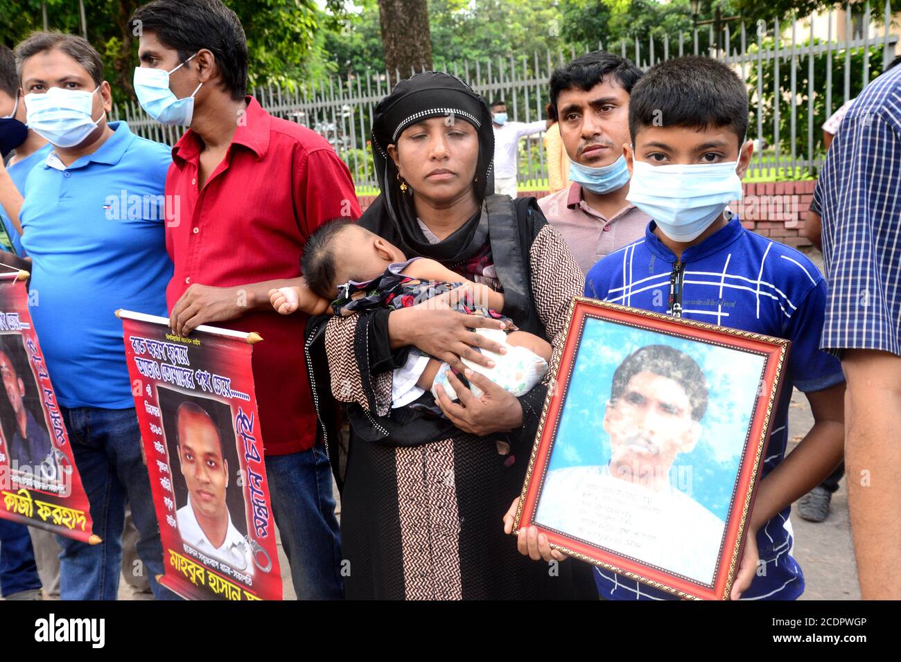 Relatives hold portraits of their missing family members as they form ...