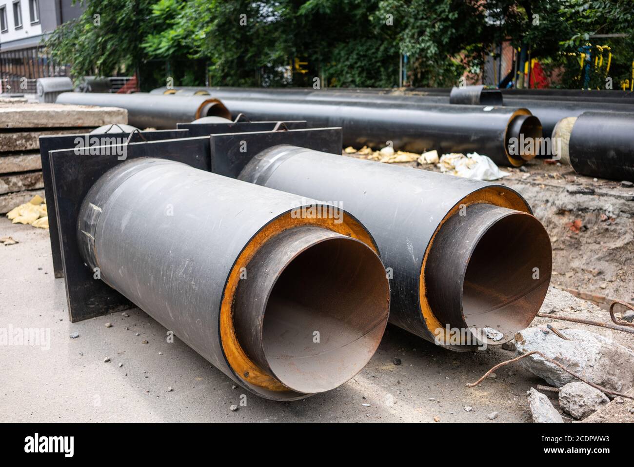 Closeup view of two new insulated water pipes on city road in summer ...