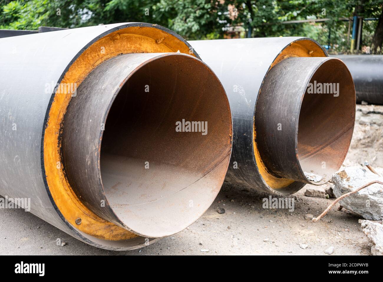 Closeup view of two new insulated water pipes on city road in summer ...