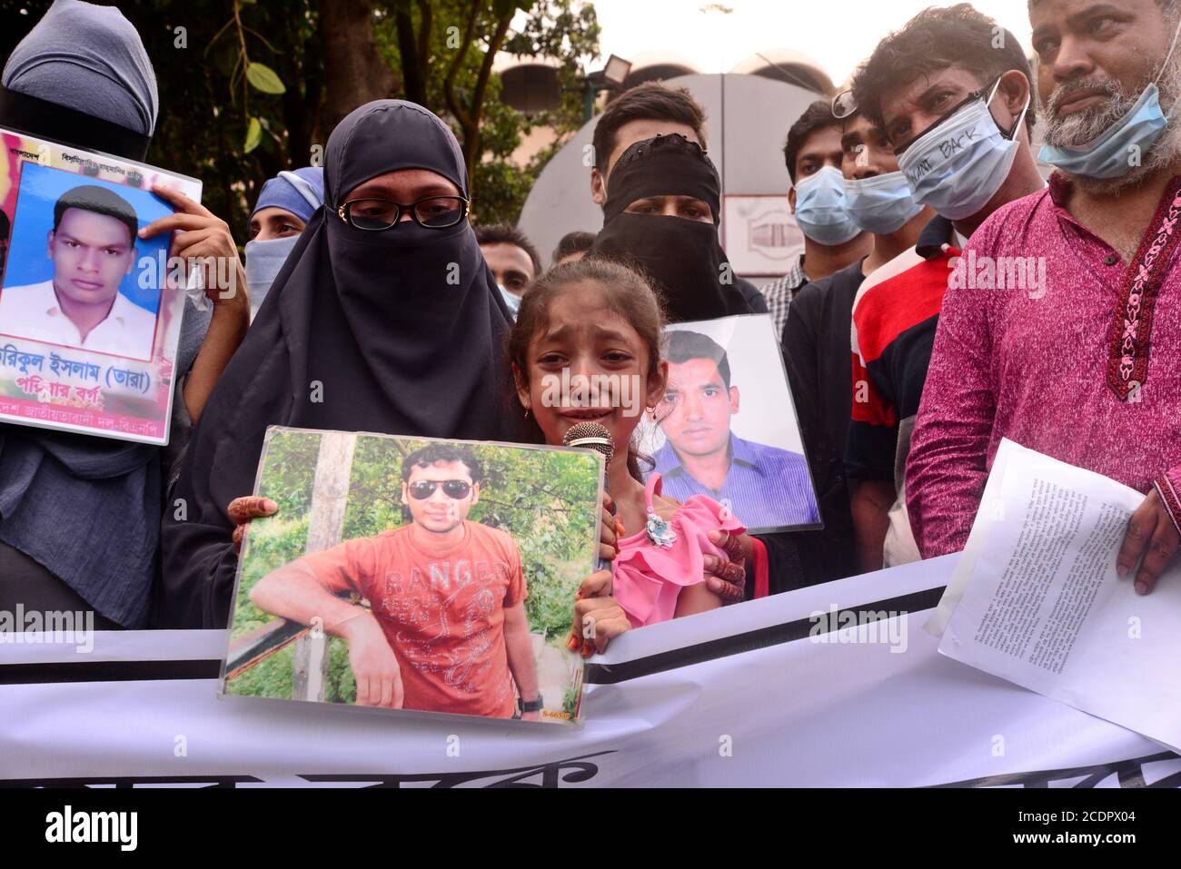 Relatives hold portraits of their missing family members as they form ...