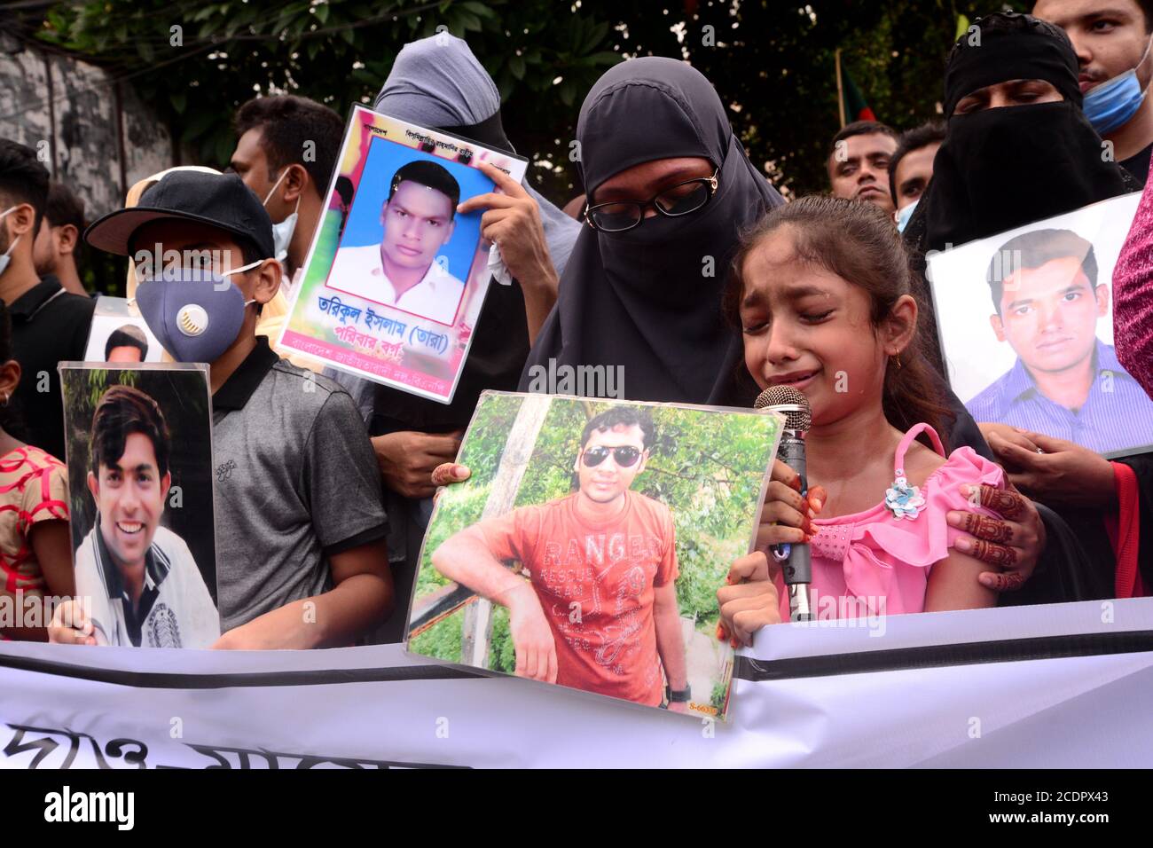 Relatives hold portraits of their missing family members as they form ...