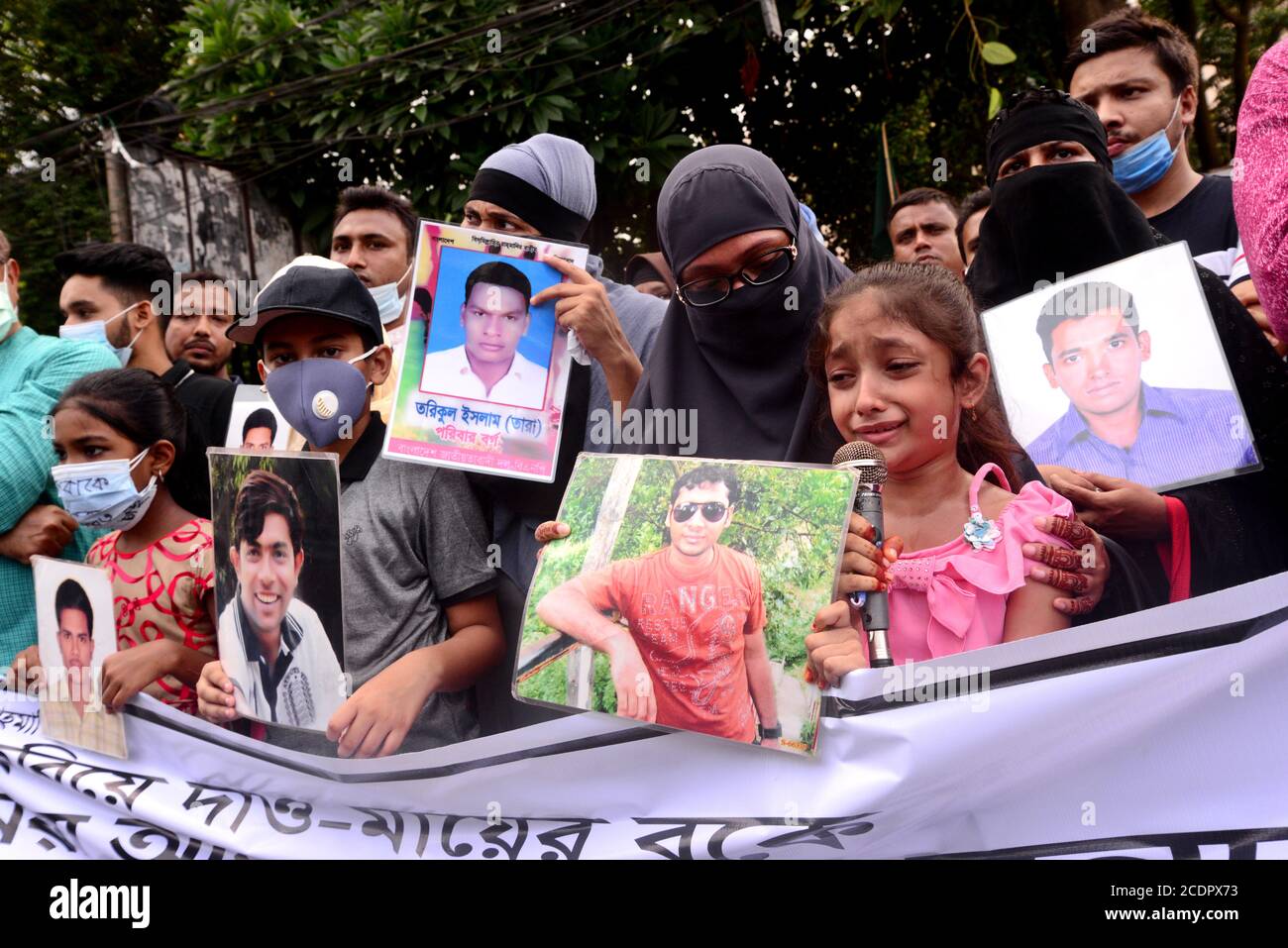 Relatives hold portraits of their missing family members as they form ...