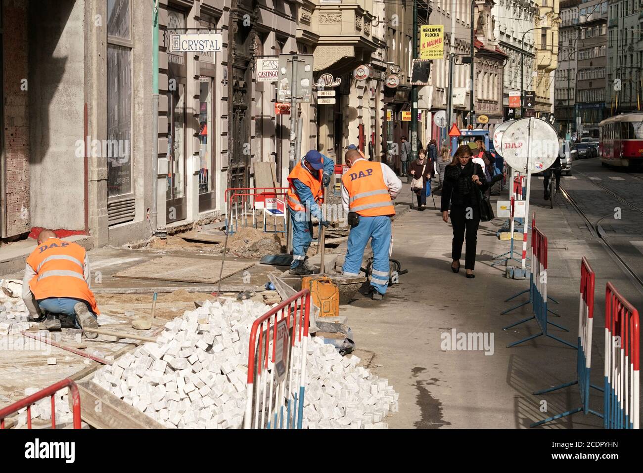 Construction workers renovate a walkway with paving stones in the city ...
