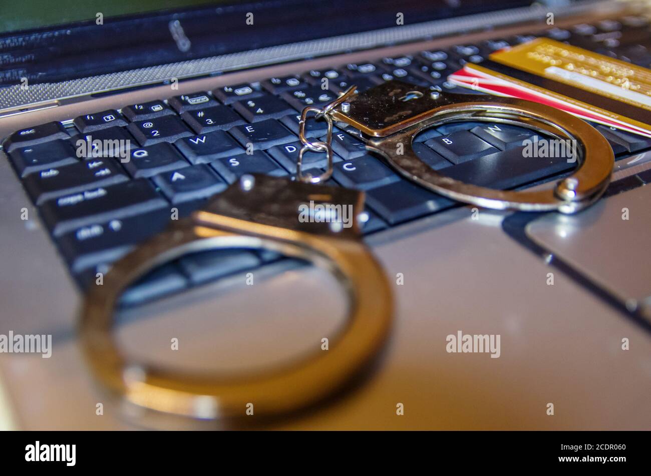 handcuffs, card on a laptop Stock Photo - Alamy