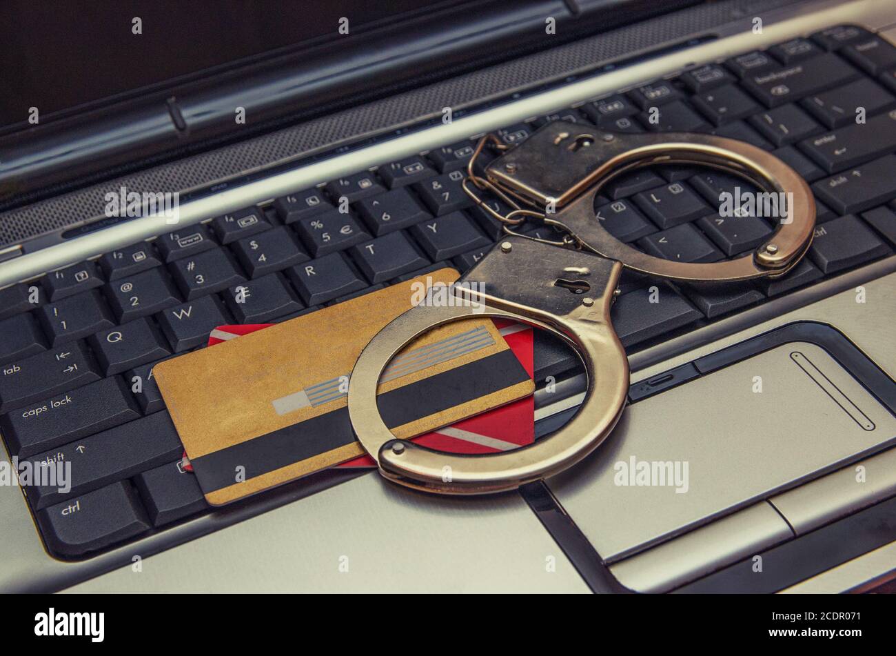 handcuffs, card on a laptop Stock Photo - Alamy