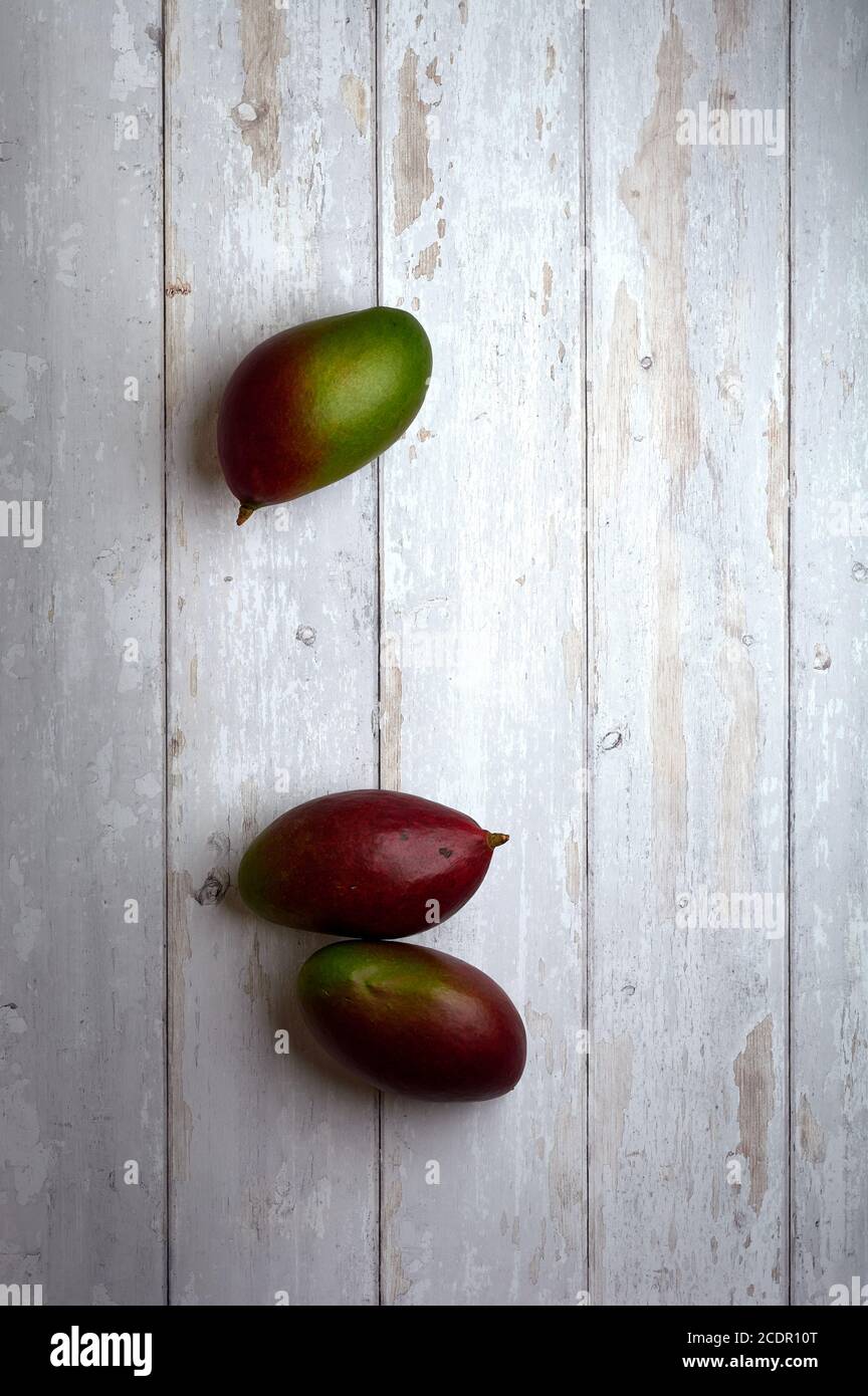 set of mangoes, cut and uncut, on a light white background of ...