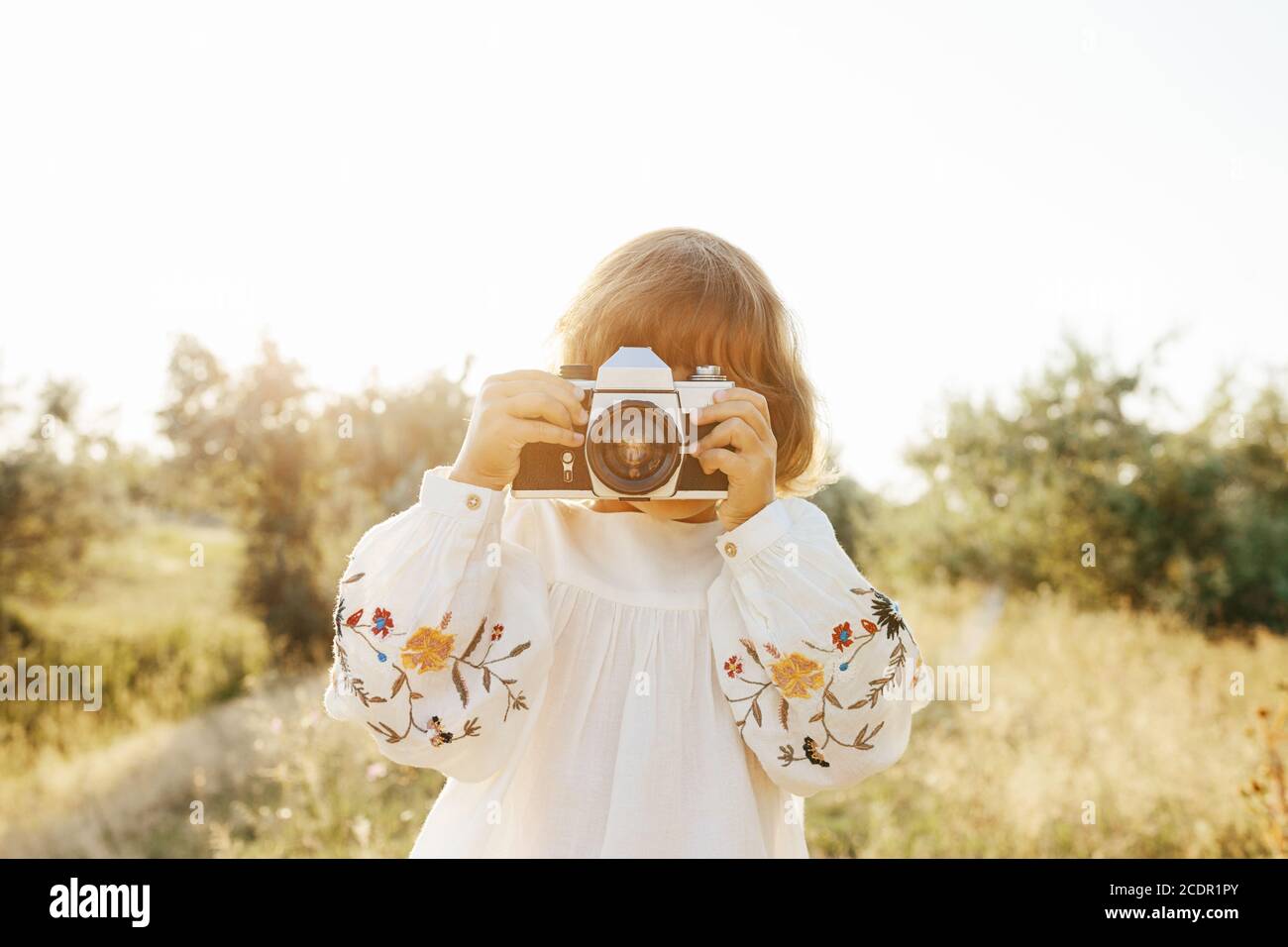 Little girl in embroidery blouse, rustic style dress, photographing ...