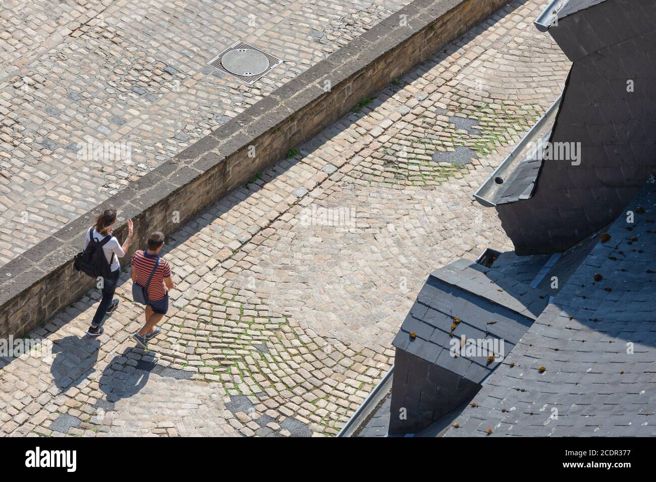 View man and woman walking over medieval pavement Luxembourg city Stock ...