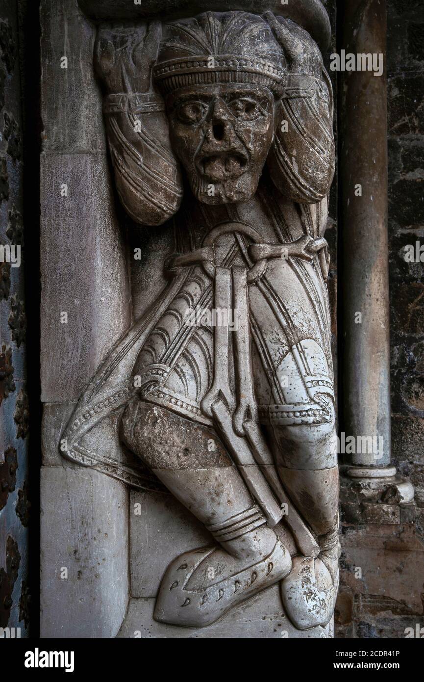 Shackled prisoner, knees buckling under the weight of his heavy burden ...