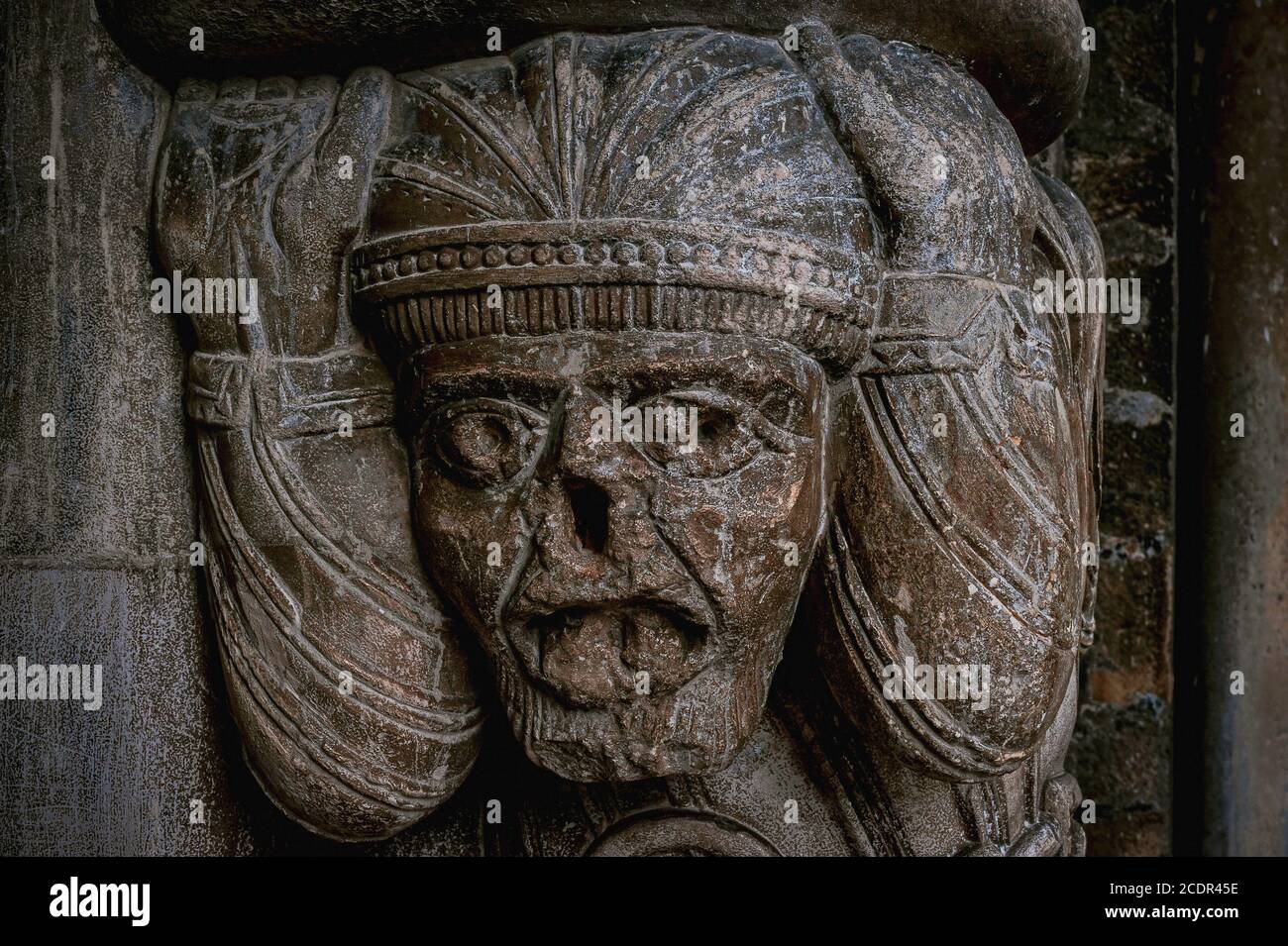 Face of exhaustion and despair. Medieval Romanesque stone telamon helps ...